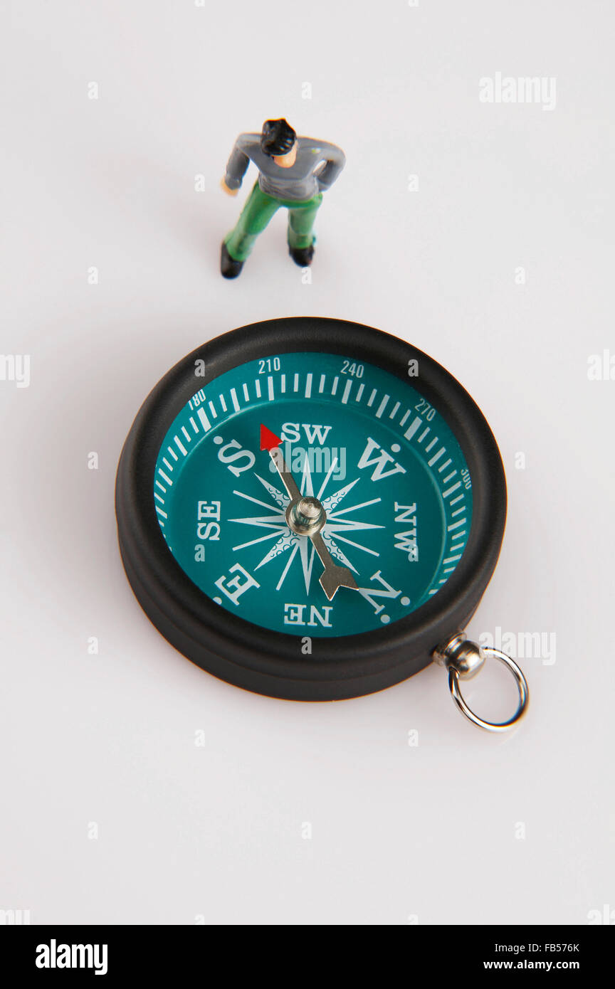 figurine stand infront of compass Stock Photo - Alamy