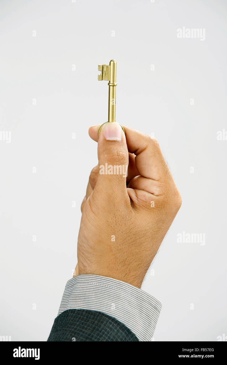 man showing a key with the white background Stock Photo - Alamy