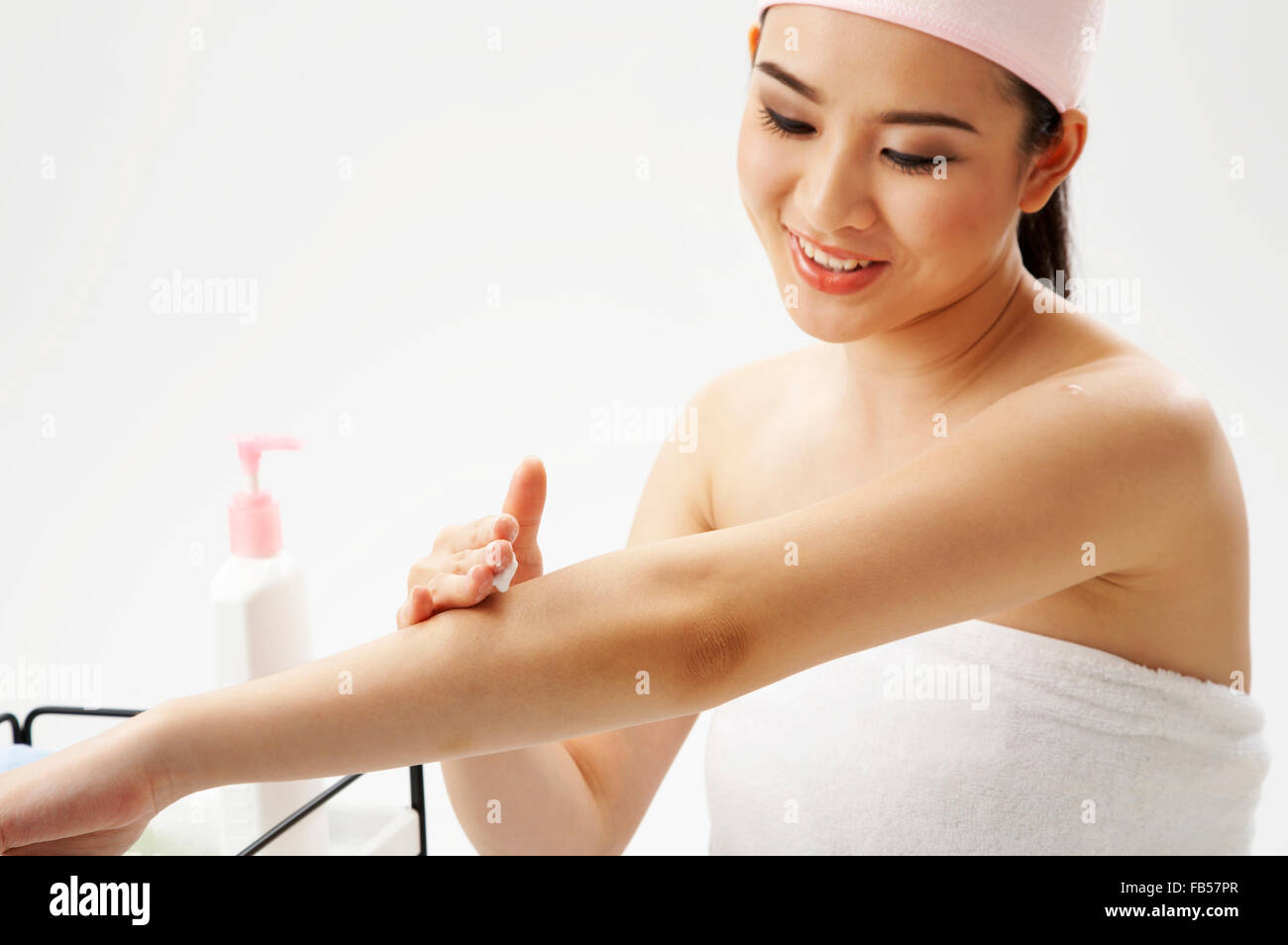 young woman applying lotion Stock Photo - Alamy