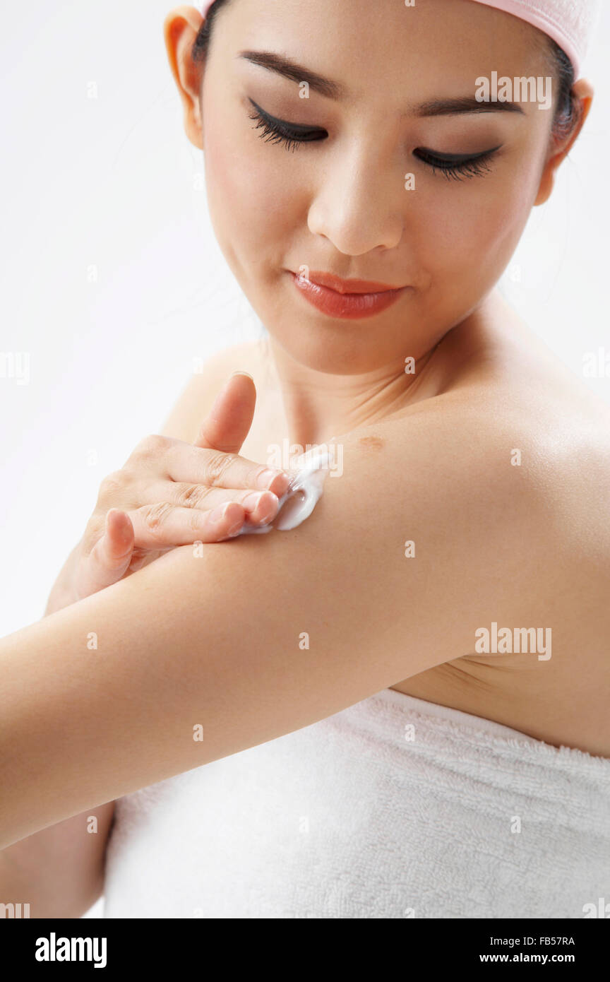 young woman applying lotion Stock Photo - Alamy