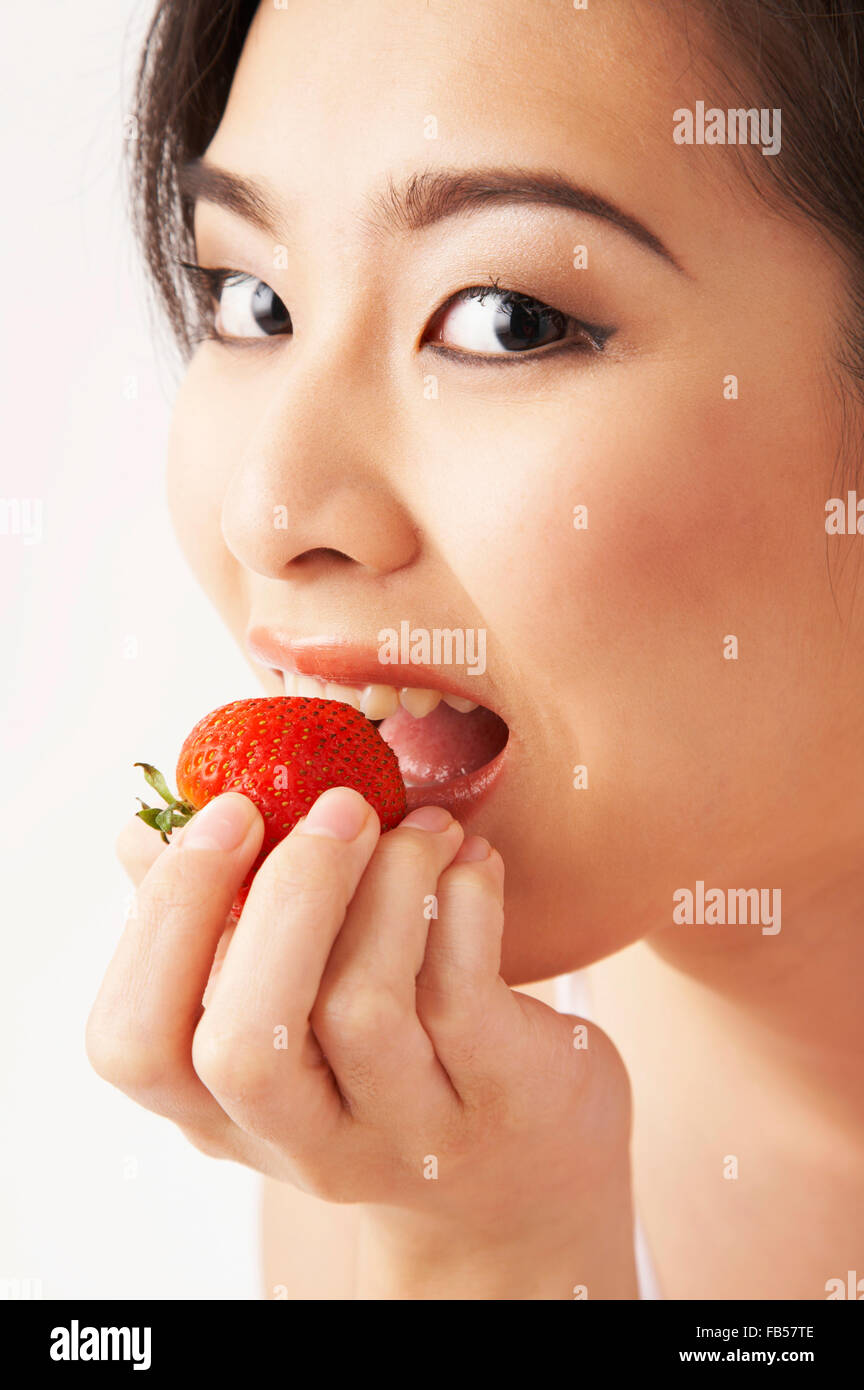 young woman eating strawberry Stock Photo - Alamy