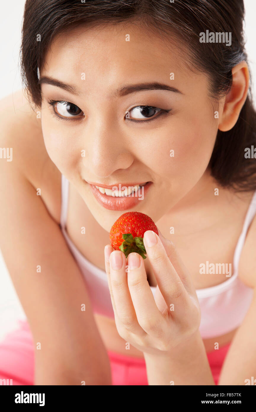 young woman eating strawberry Stock Photo - Alamy