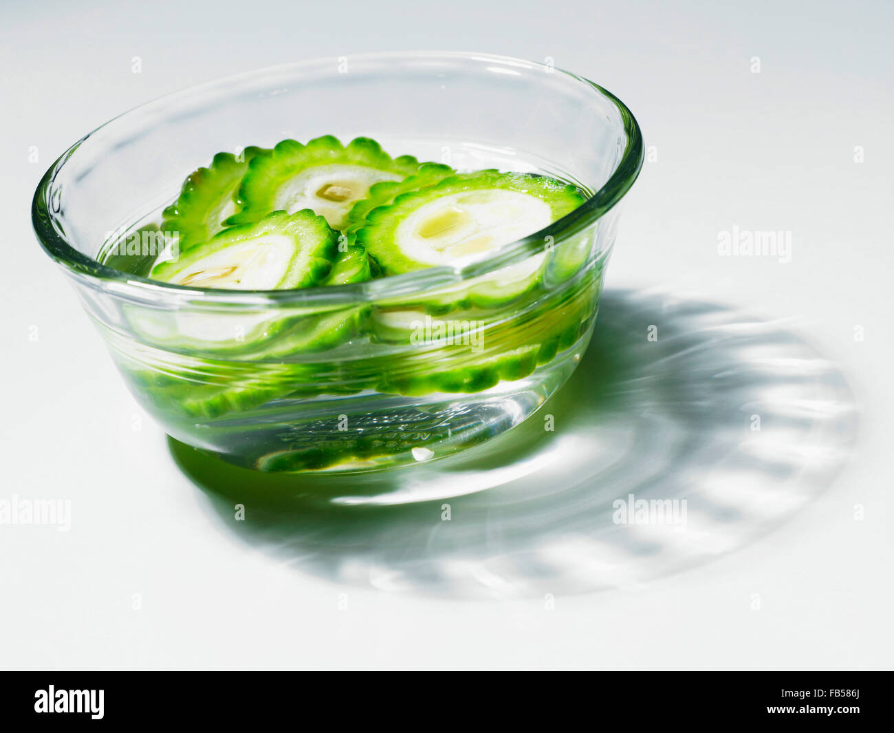 a bowl of sliced bitter guard on the white background Stock Photo - Alamy