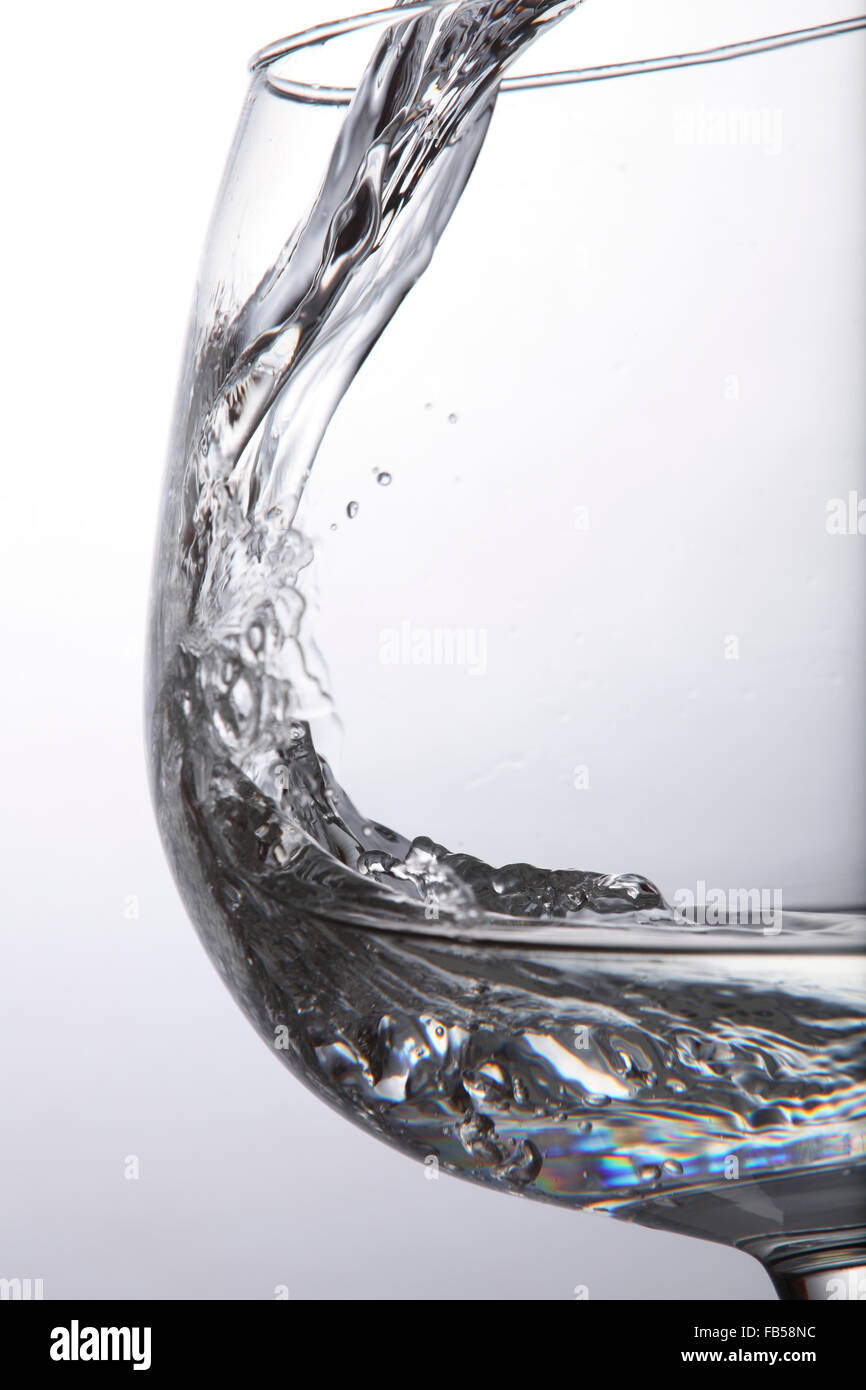 pouring water to the container with white background Stock Photo - Alamy