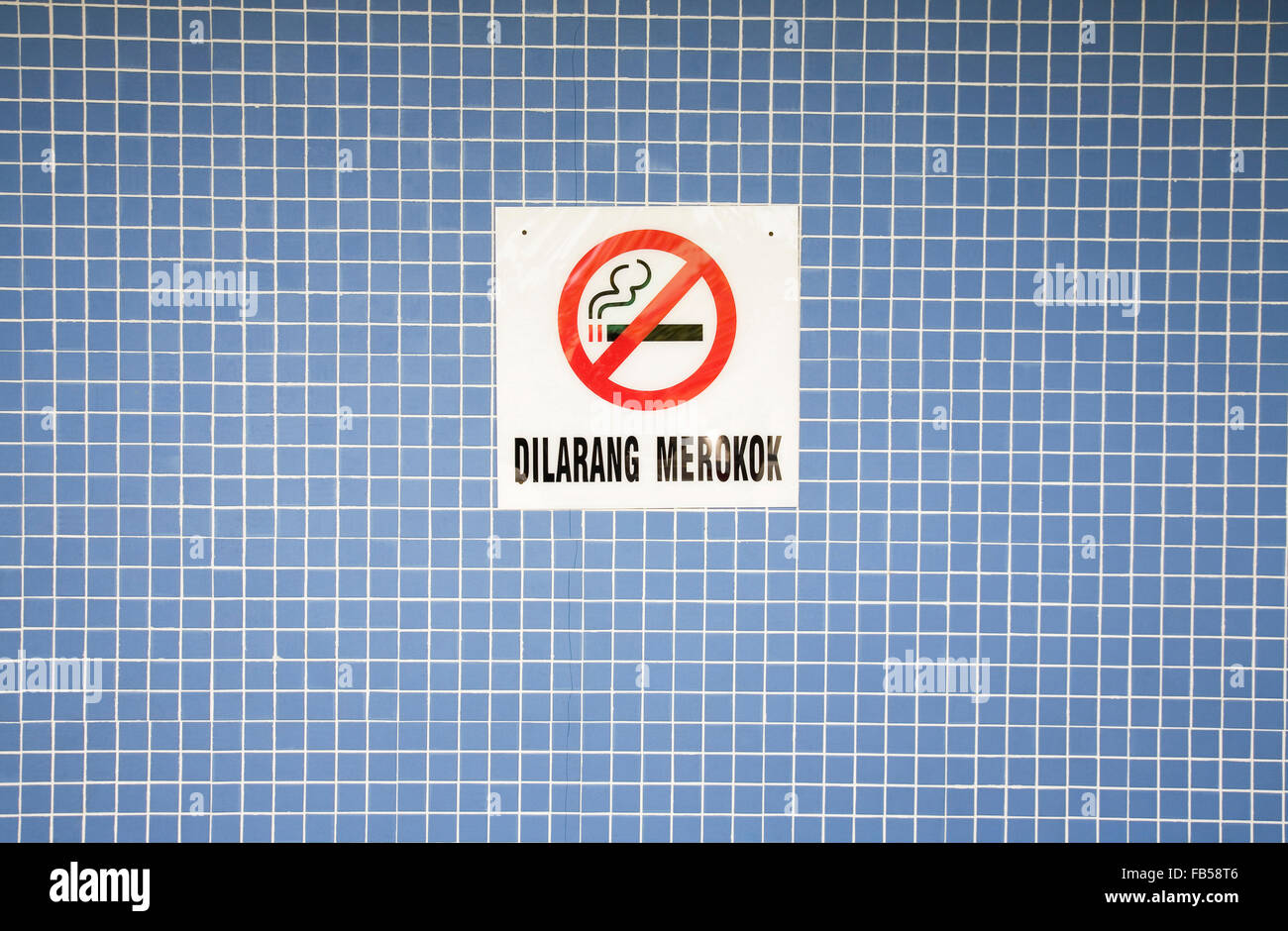 No smoking sign on blue color tiles wall Stock Photo - Alamy