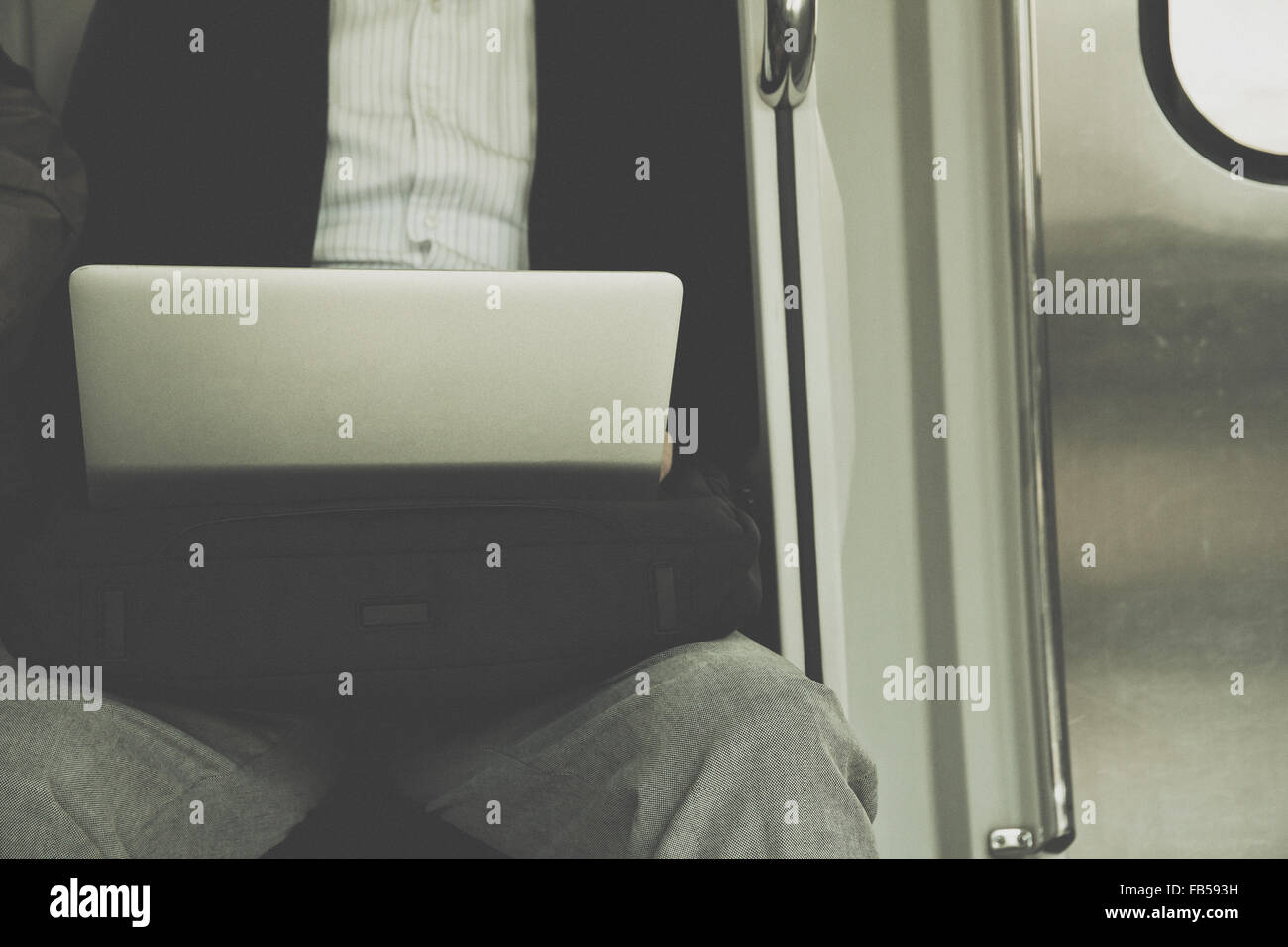 Businessman sitting on seat of train and playing Laptop Stock Photo - Alamy