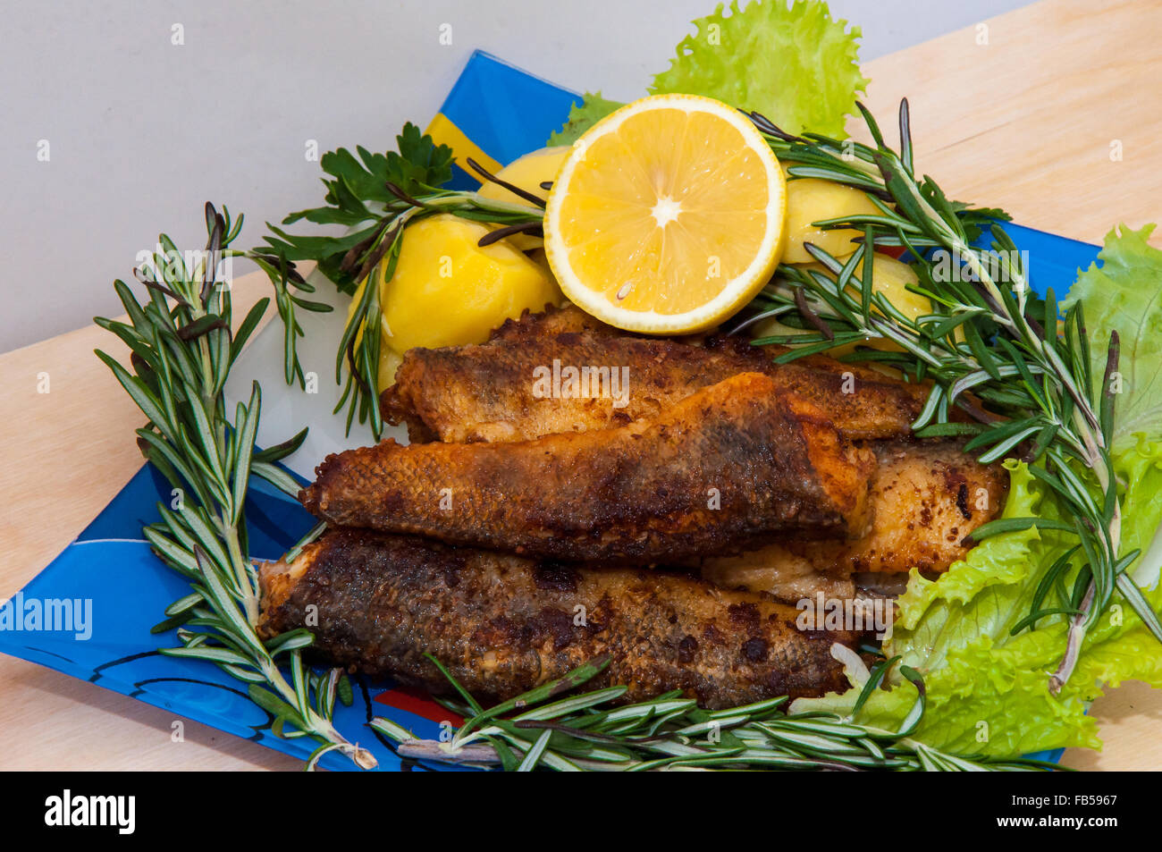 Marine fried fish with fresh herbs on the table Stock Photo - Alamy