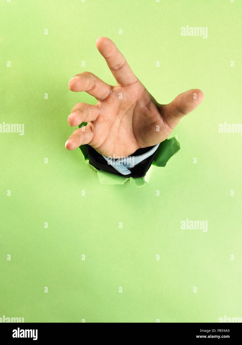 hand gesture break through green paper with action Stock Photo - Alamy