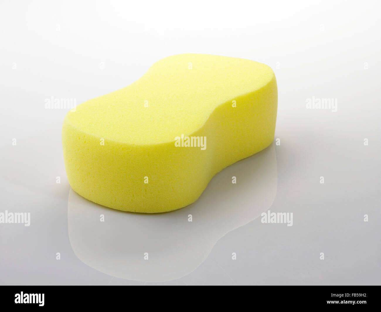 a piece of yellow sponge on the plain background Stock Photo - Alamy