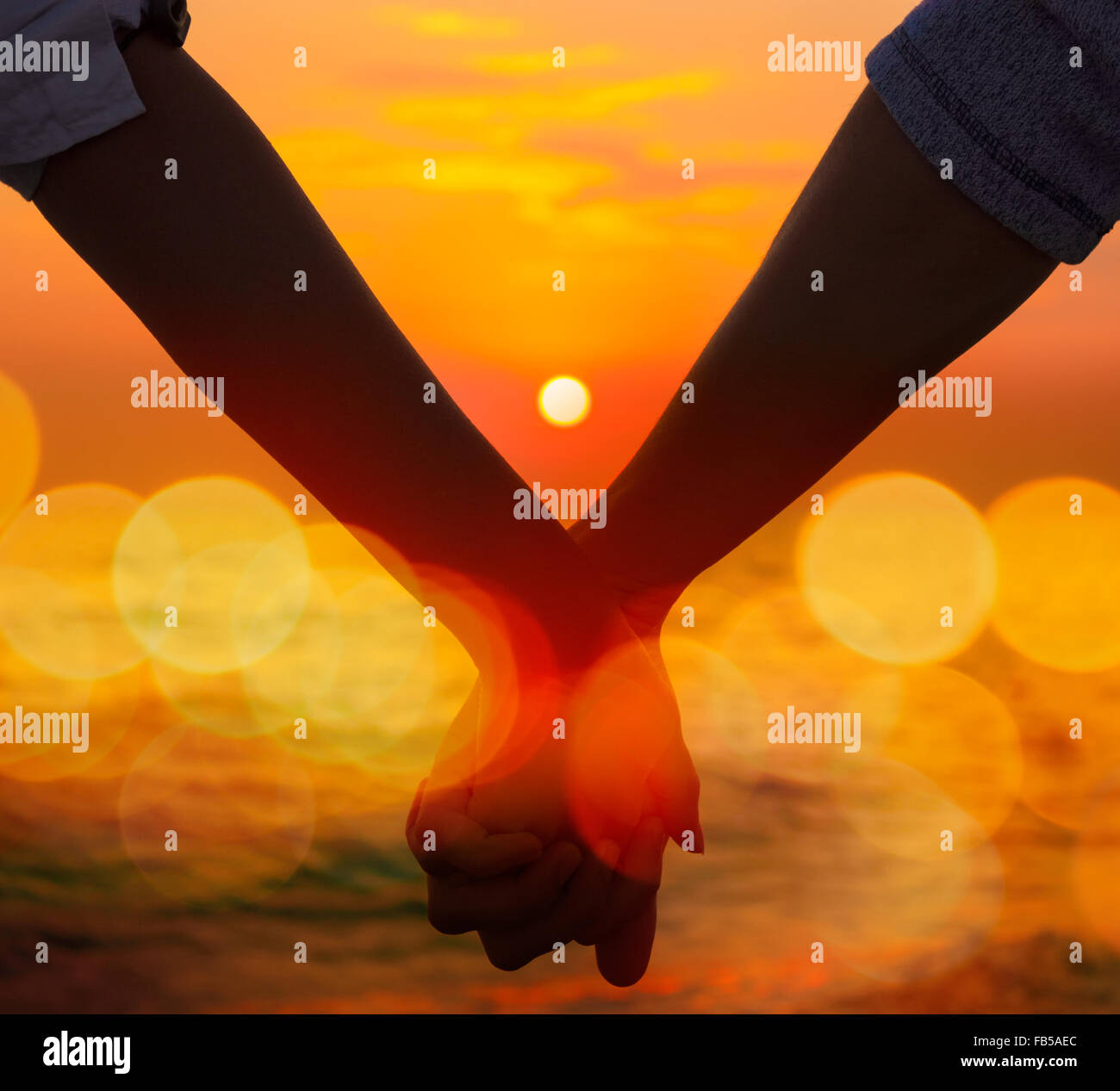 Couple Holding Hands at Sea Sunset Stock Photo - Alamy