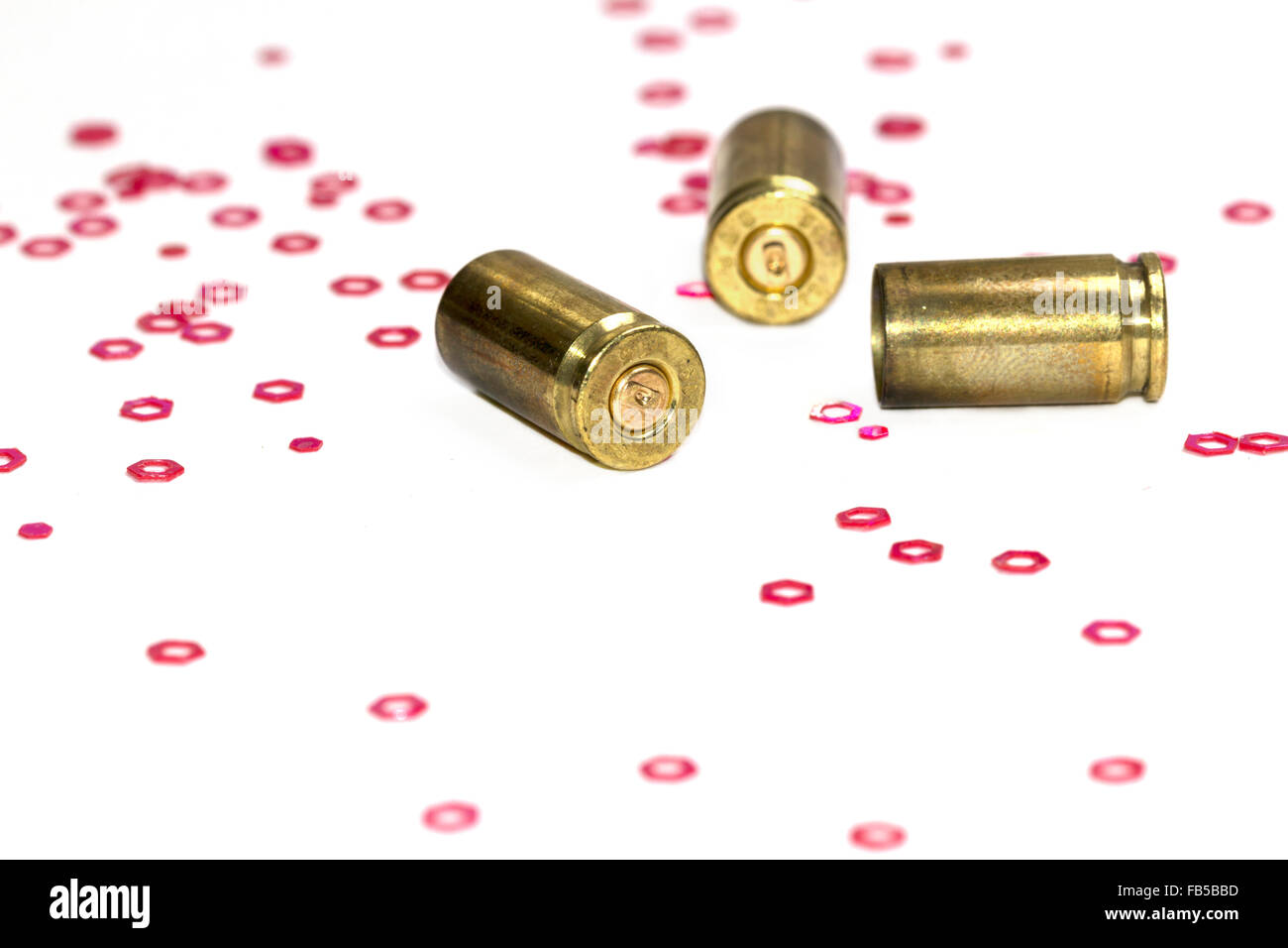 Empty 9mm bullet shells over white background with red hexagon small ...