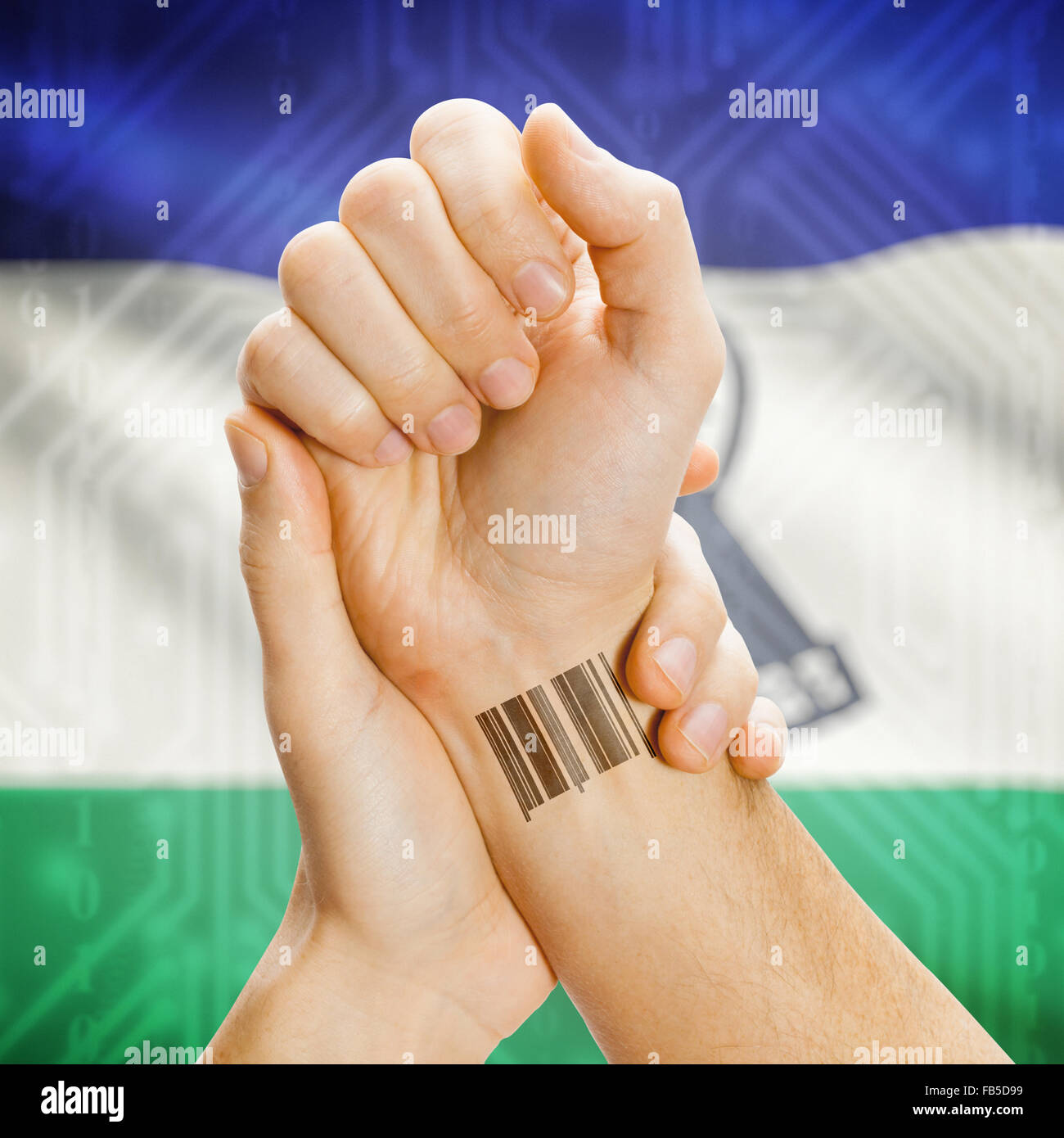 Barcode ID number on wrist of a human and national flag on background ...