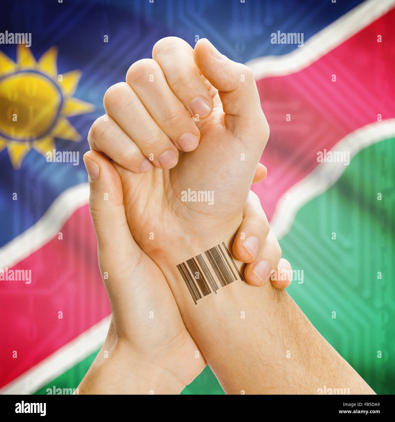 Barcode ID number on wrist of a human and national flag on background ...