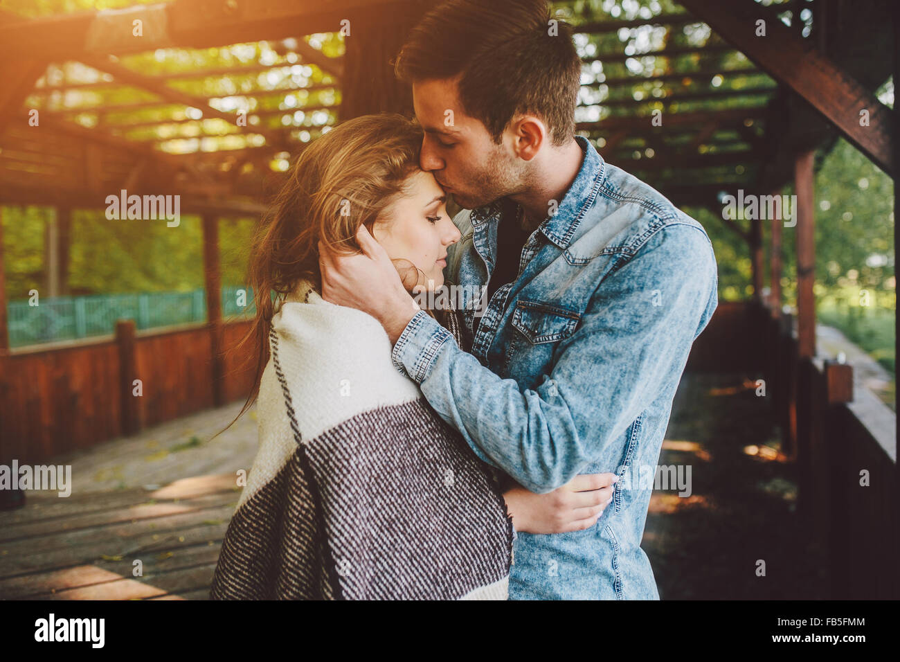 Woman standing behind man kissing hi-res stock photography and images ...
