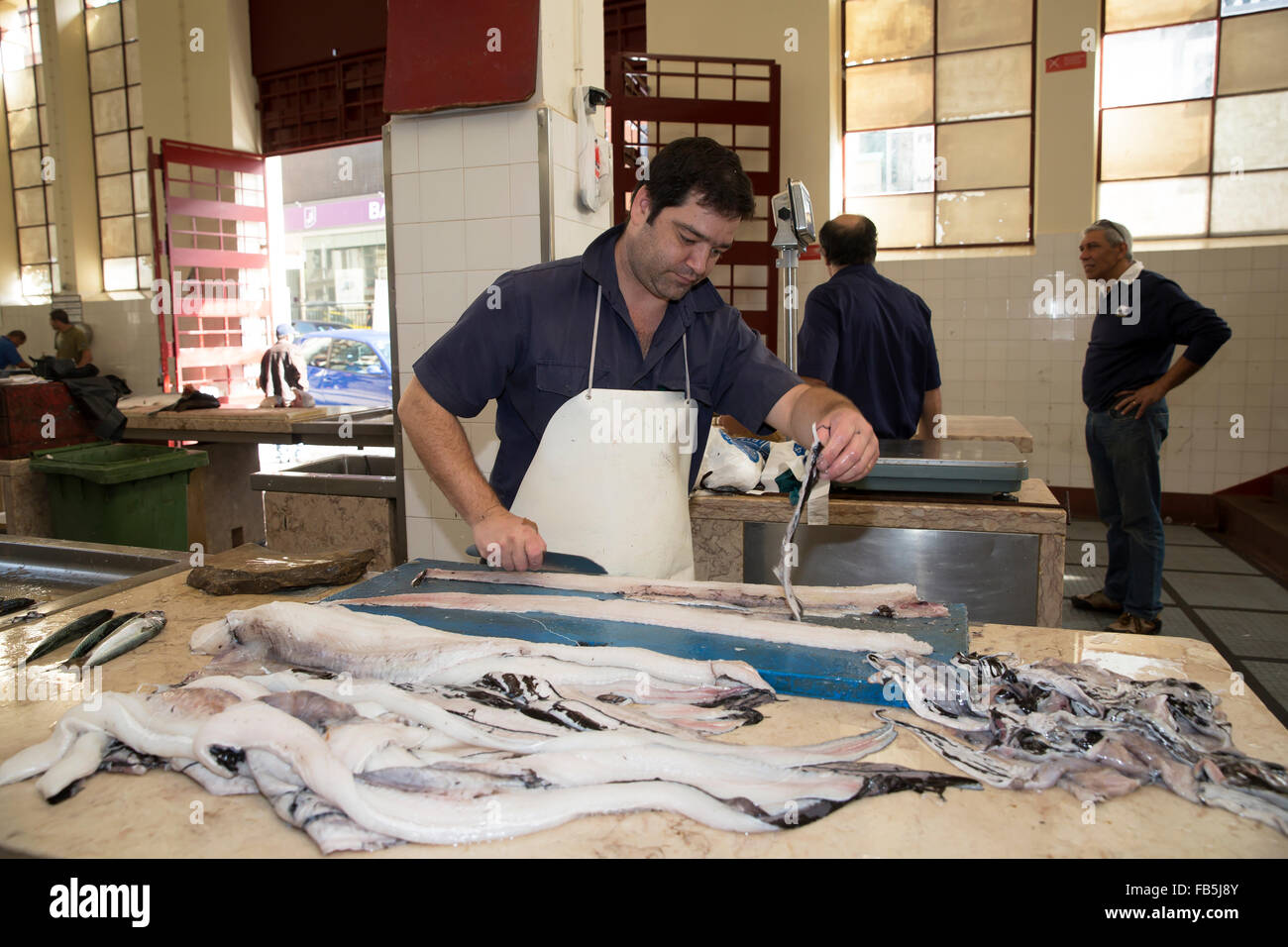 Fishmonger cutting fish in the public market in Madeira Stock Photo - Alamy