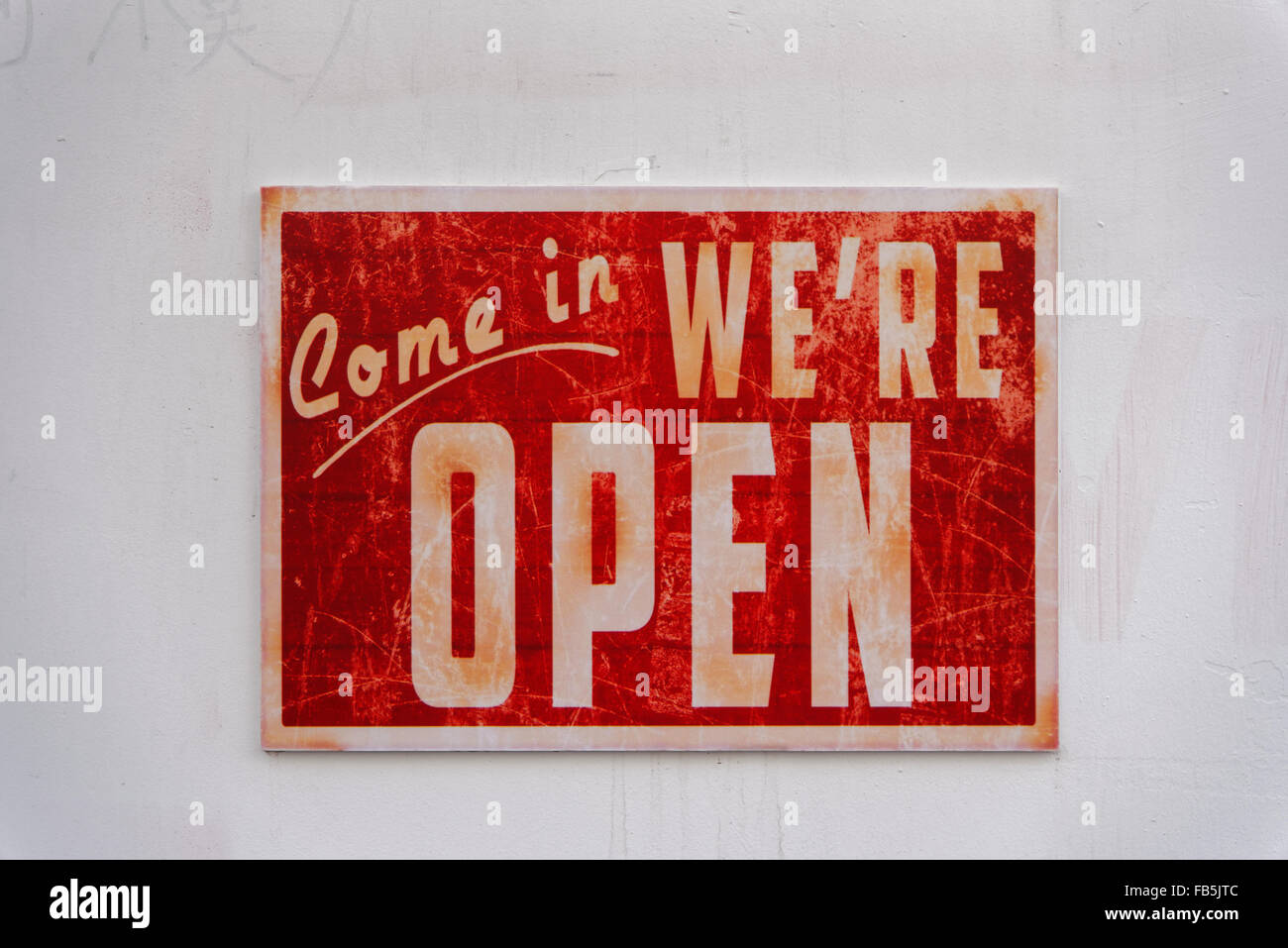 Come in we're open red sign on a wall Stock Photo - Alamy
