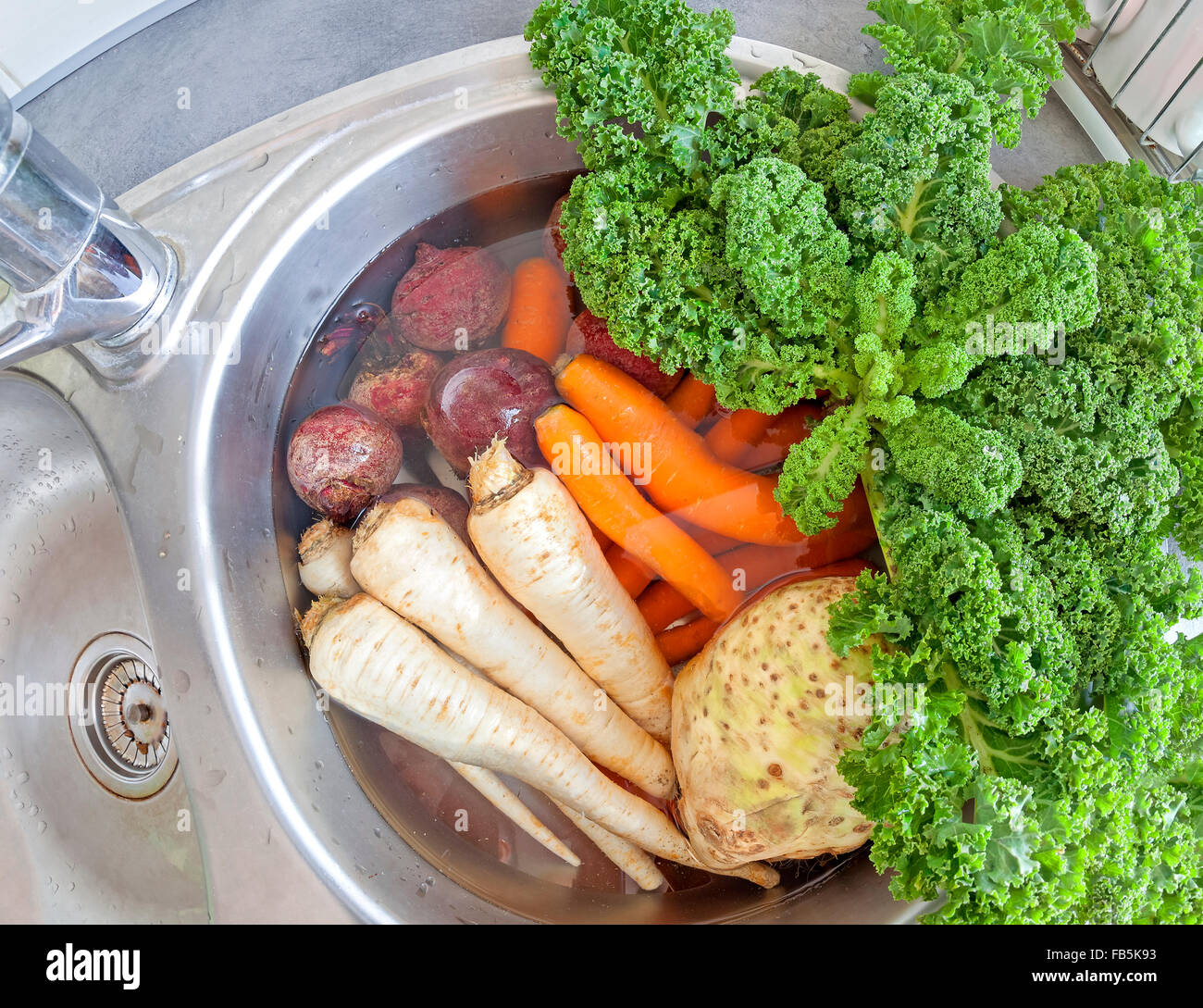 Dirty vegetables in a kitchen sink filled with water Stock Photo - Alamy