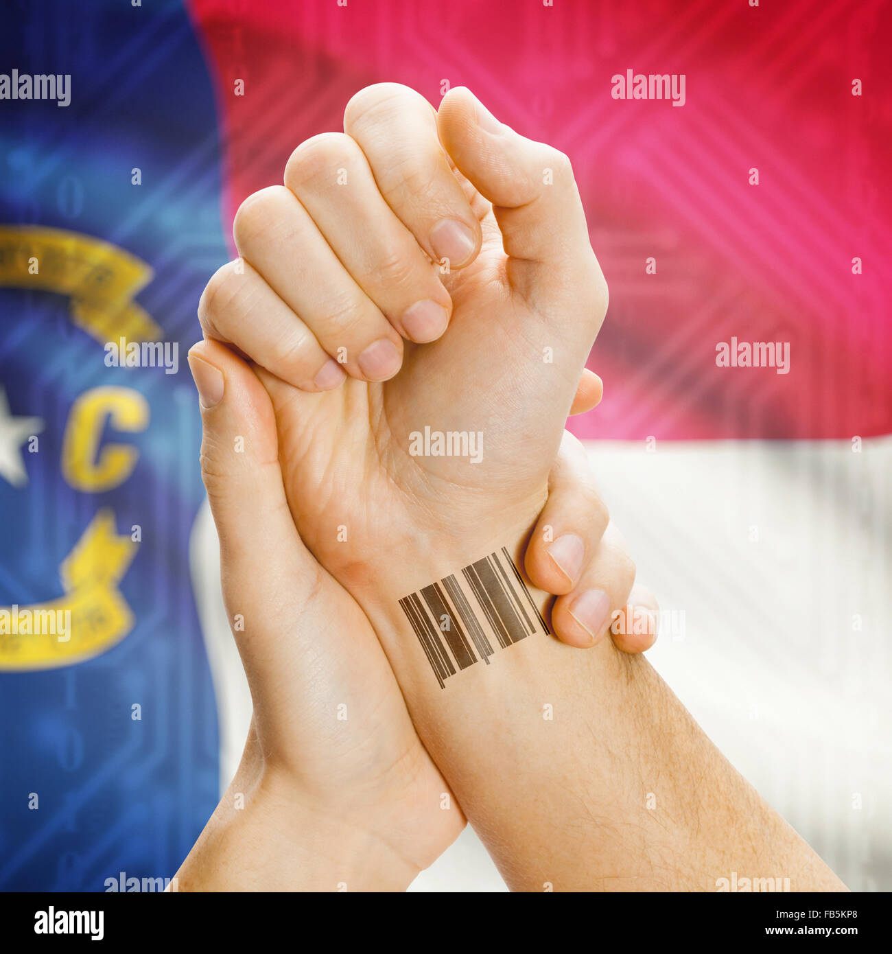 Barcode ID number tatoo on wrist and USA statesl flag on background ...