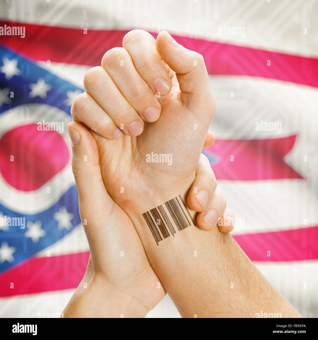 Barcode ID number tatoo on wrist and USA statesl flag on background ...