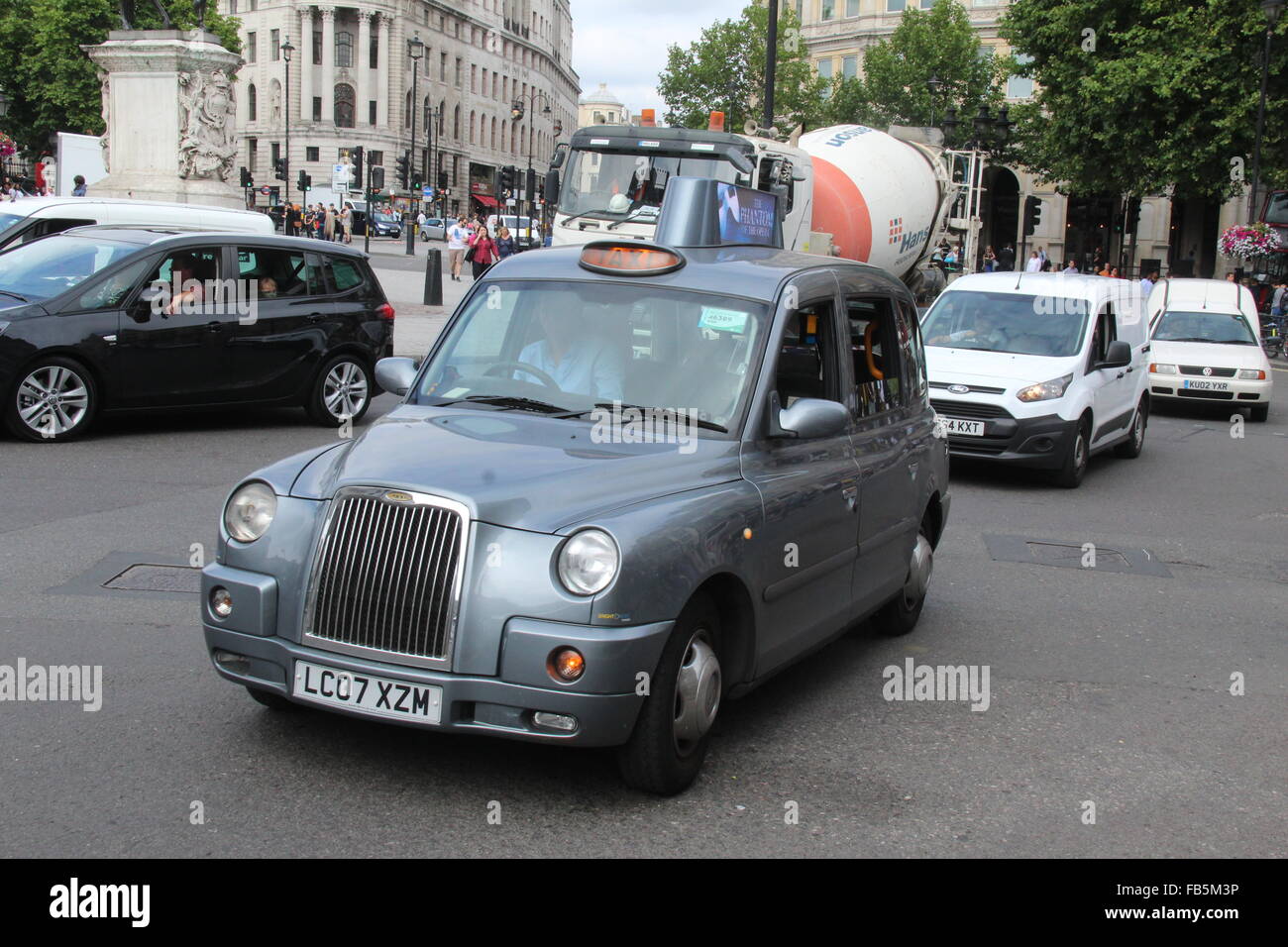 A GREY CARBODIED TX LONDON TAXI CAB PASSING THROUGH TRAFALGER SQUARE ...