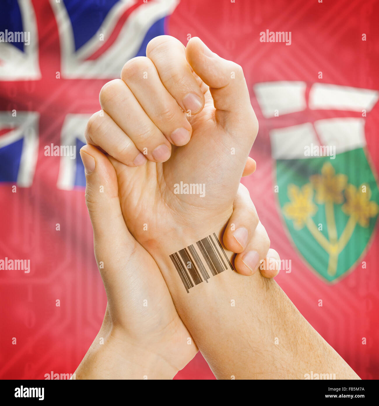 Barcode ID number tatoo on wrist and Canadian province flag on ...