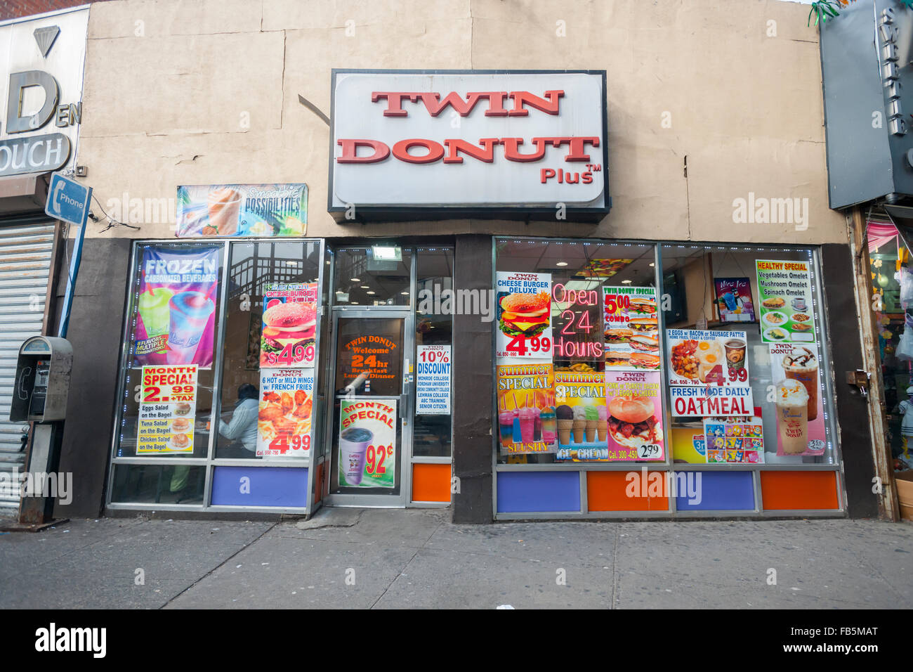 The menu of a Twin Donut Plus cafe is plastered all over the windows in ...