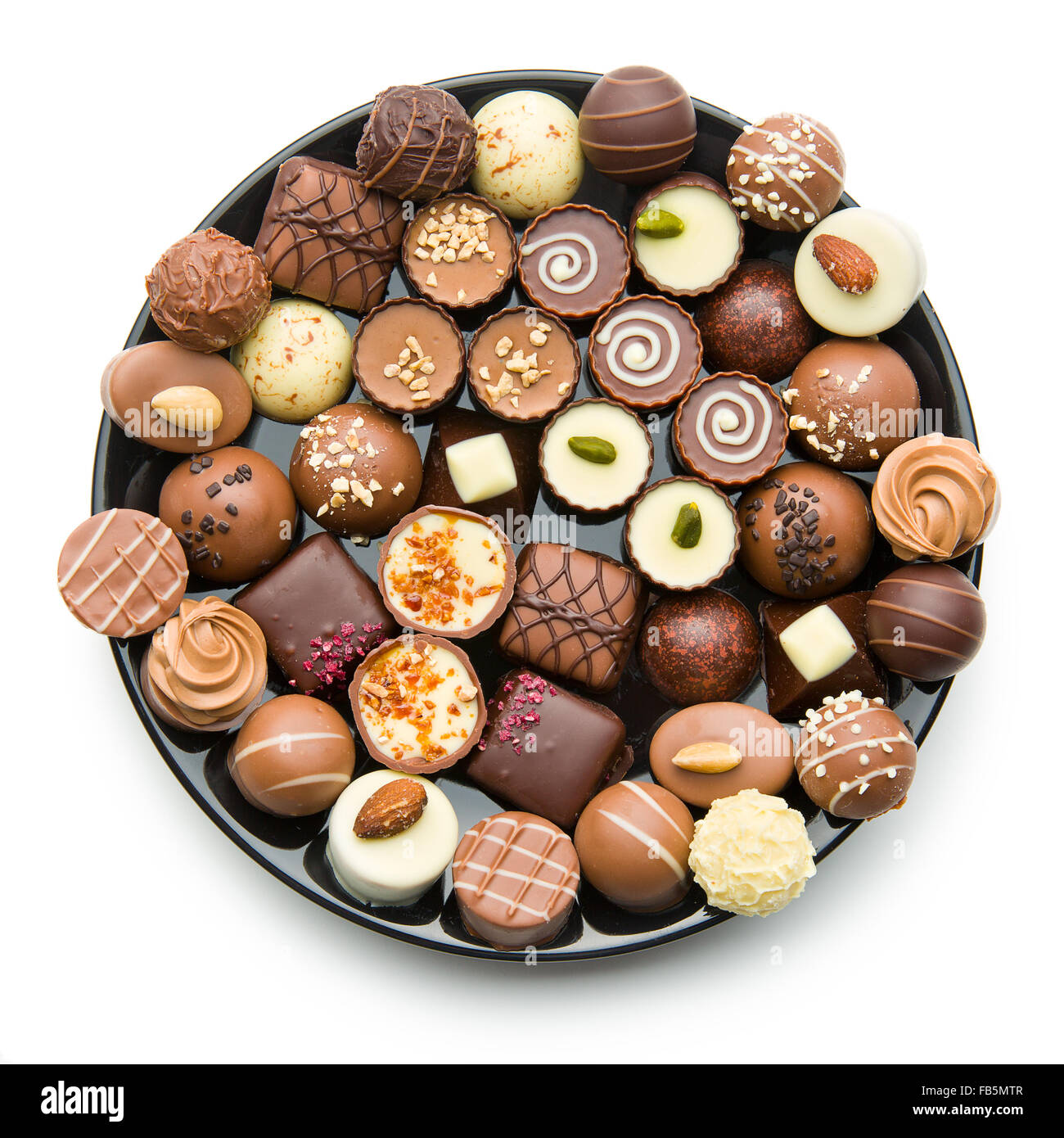various chocolate pralines on black plate Stock Photo - Alamy