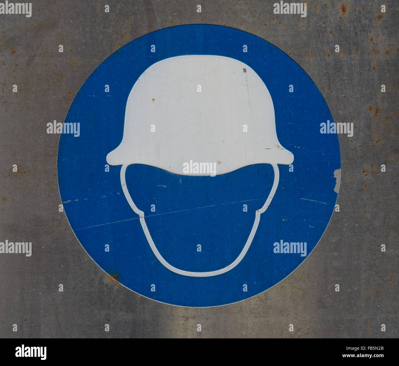 Wear a hard hat sign on a painted on a metal surface Stock Photo - Alamy