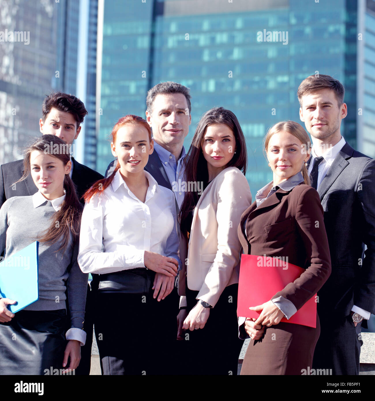 Portrait of business team outside office on skyscrapers background ...