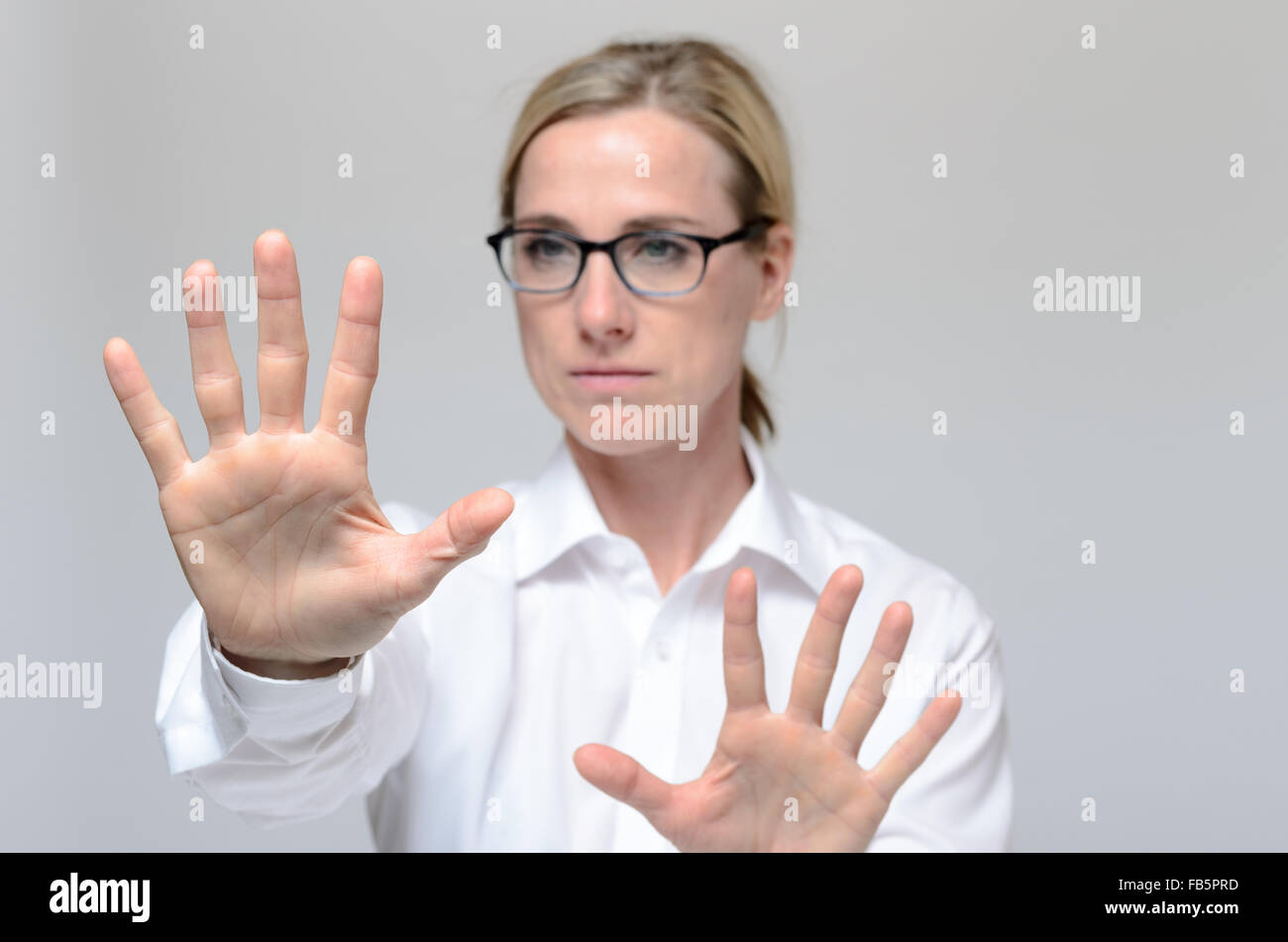 Businesswoman standing against grey background and using Hands on ...