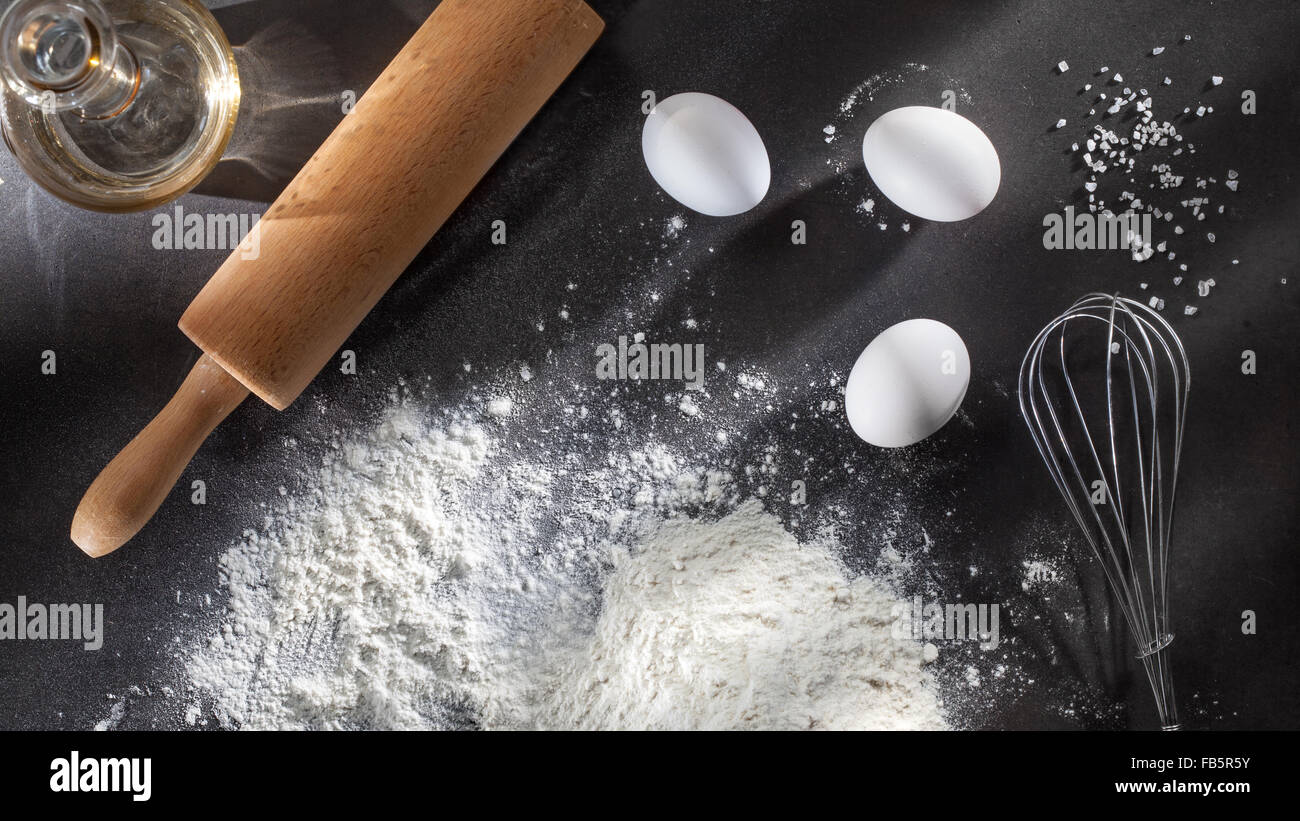 flour and ingredients on black table. Top view Stock Photo - Alamy