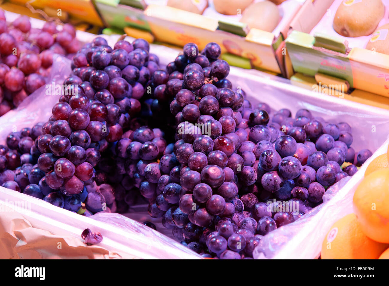 Pile of purple grapes on a market shelf Stock Photo - Alamy