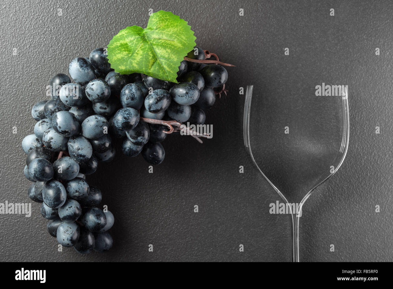 Wine glass made of forks and grape on black background Stock Photo - Alamy