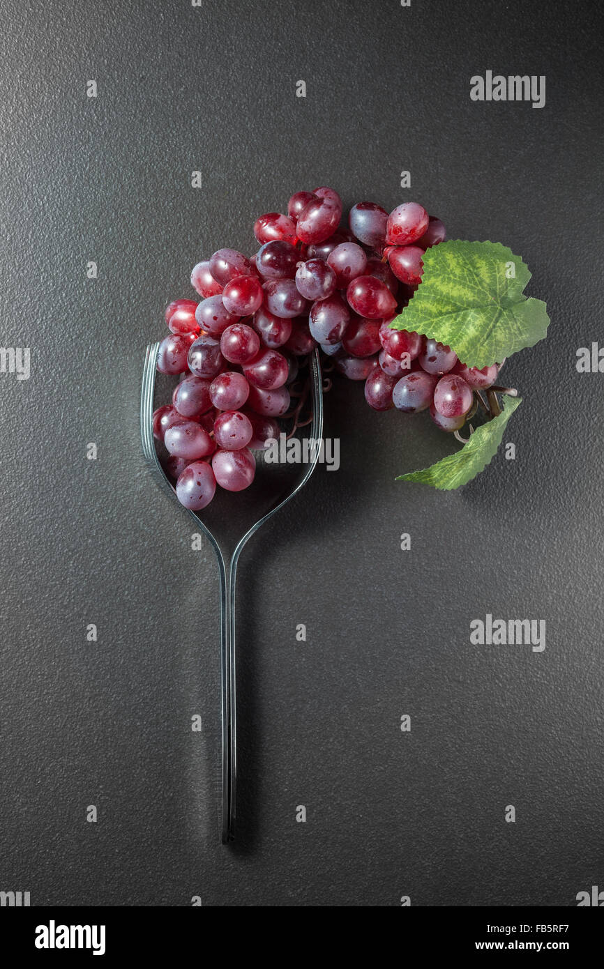 Wine glass made of forks and grape on black background Stock Photo - Alamy