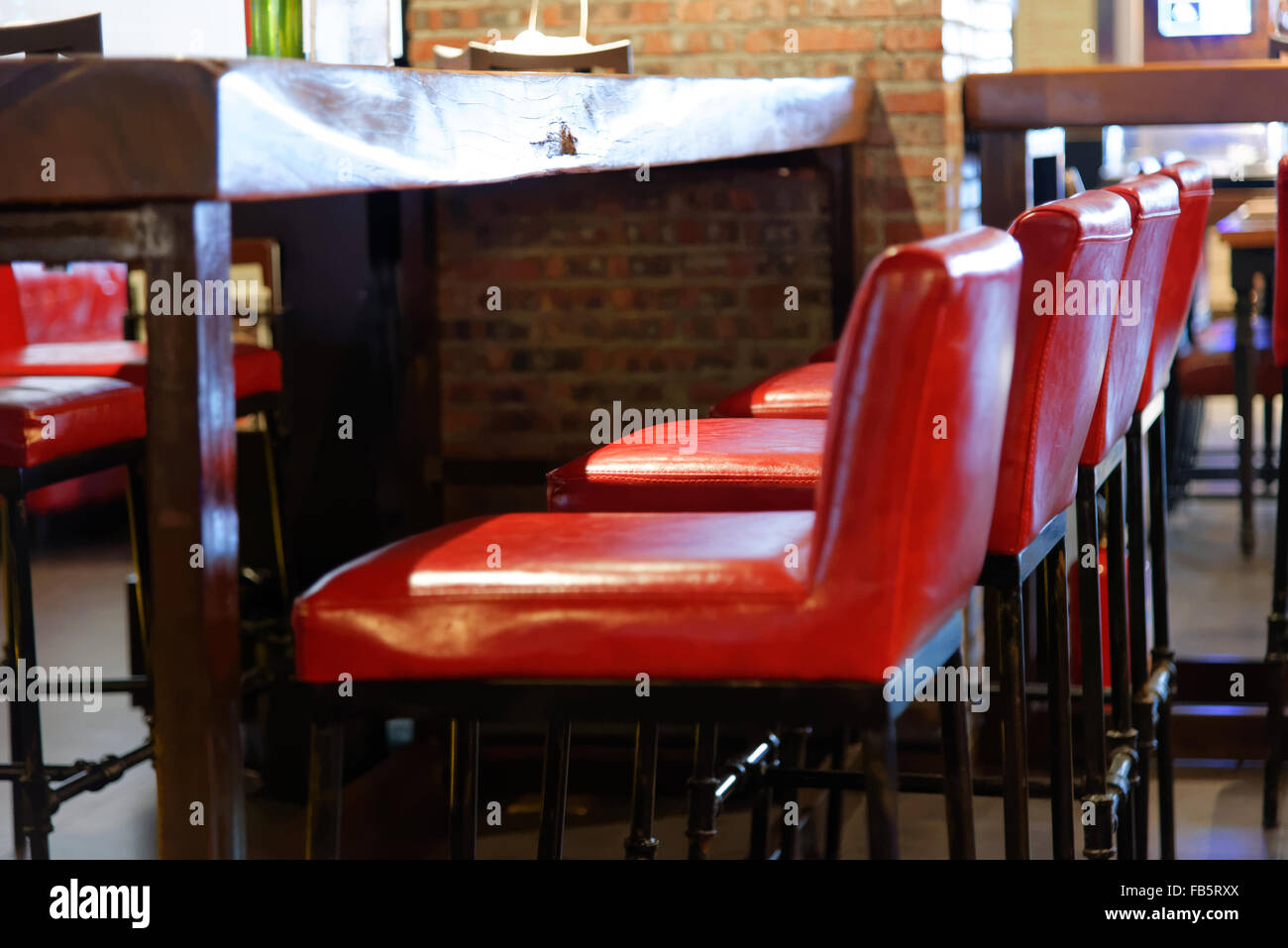 Tall red bar chairs at a bar table Stock Photo - Alamy