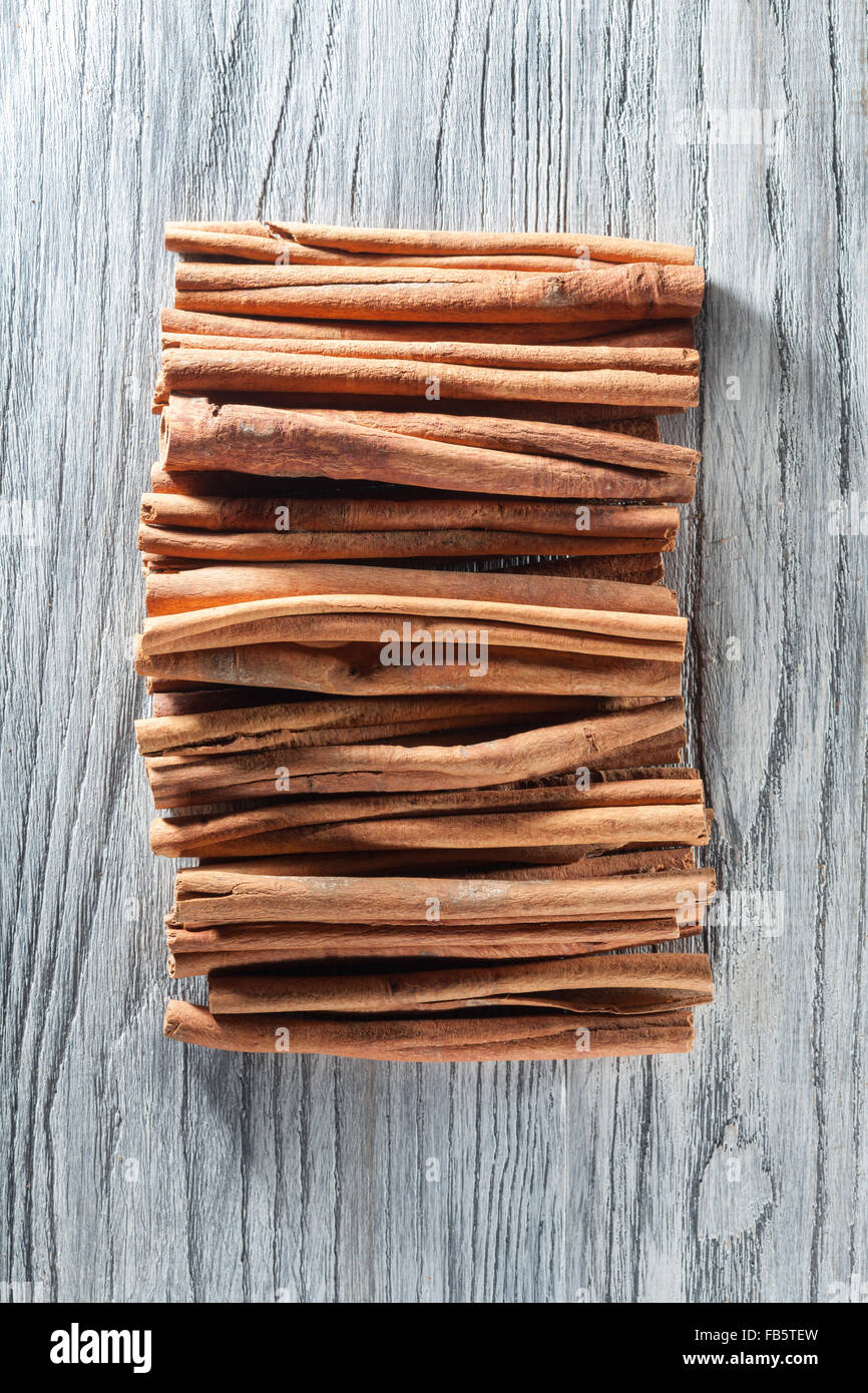 Cinnamon sticks isolated on white wooden background. Top view without ...