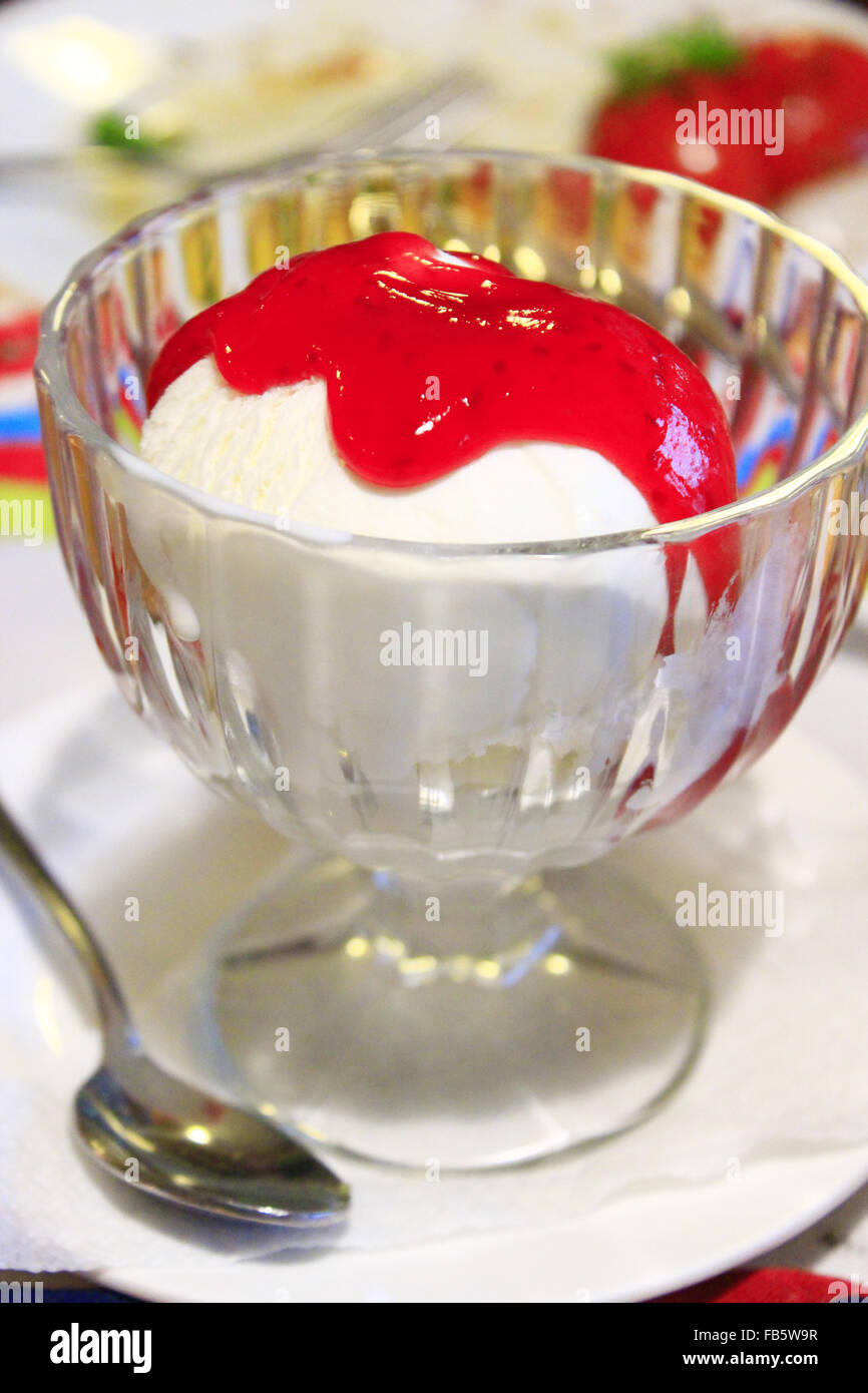 Ice cream poured red and sweet raspberry syrup Stock Photo - Alamy