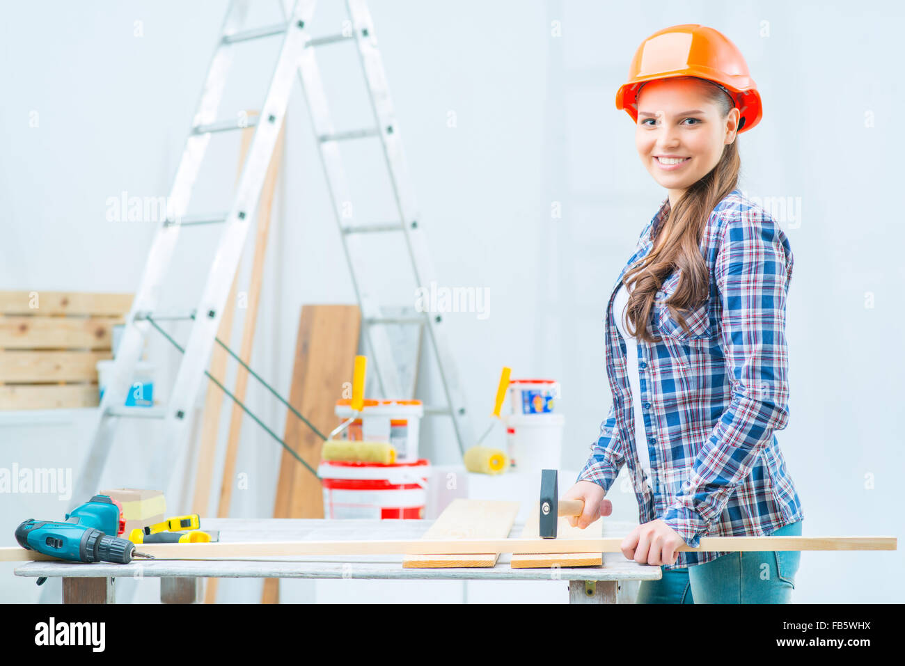 Happy woman using hammer Stock Photo - Alamy