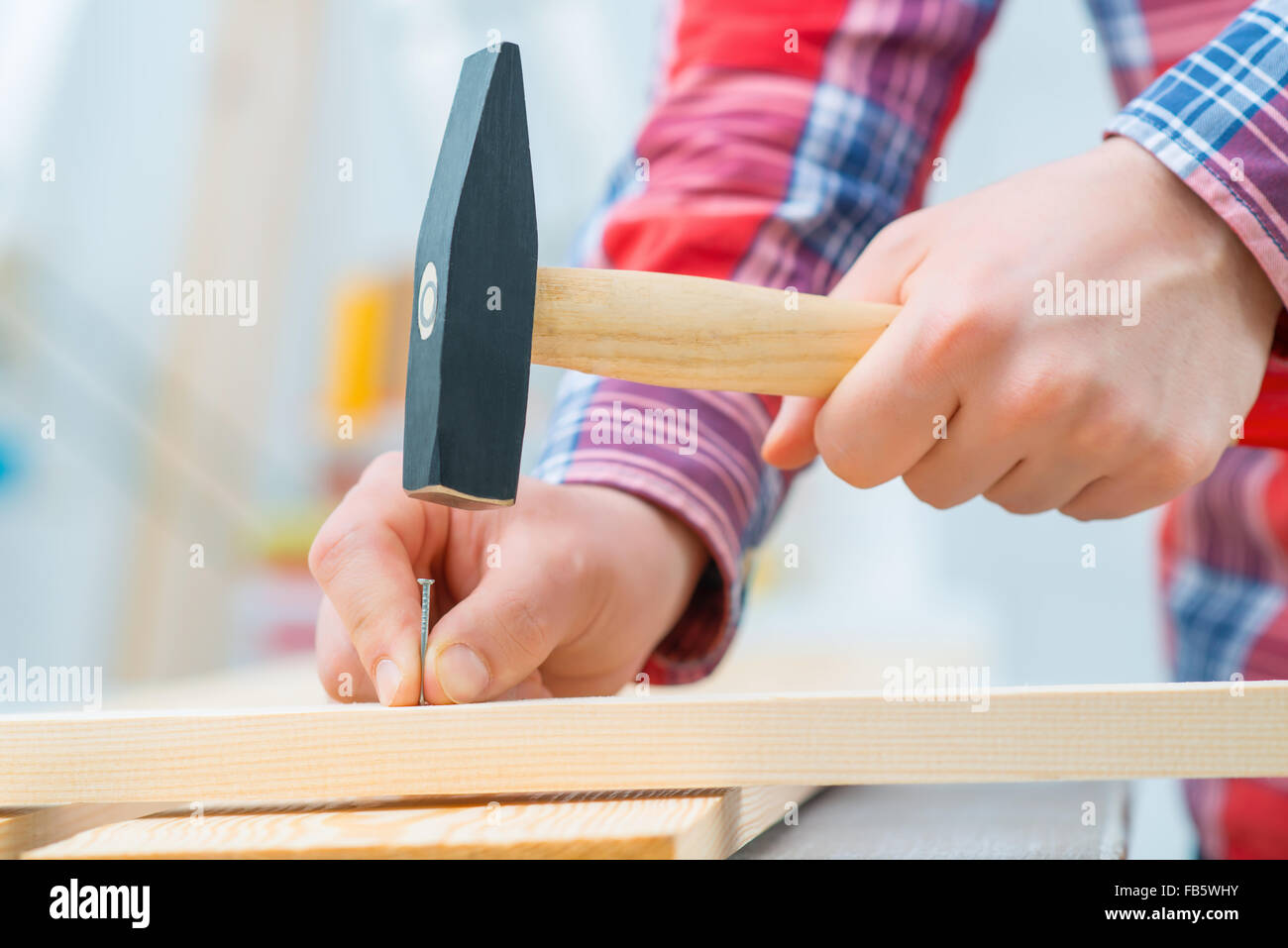 Pleasant man using hammer Stock Photo - Alamy