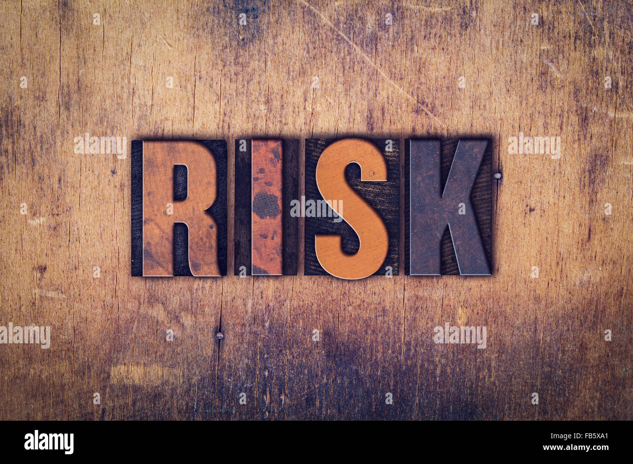 The word "Risk" written in dirty vintage letterpress type on a aged ...