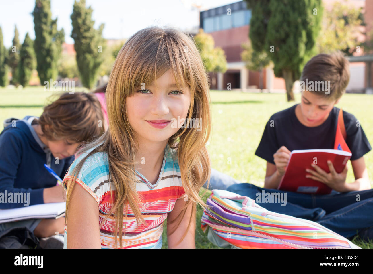 Group of little students sitting on the grass at school Stock Photo - Alamy