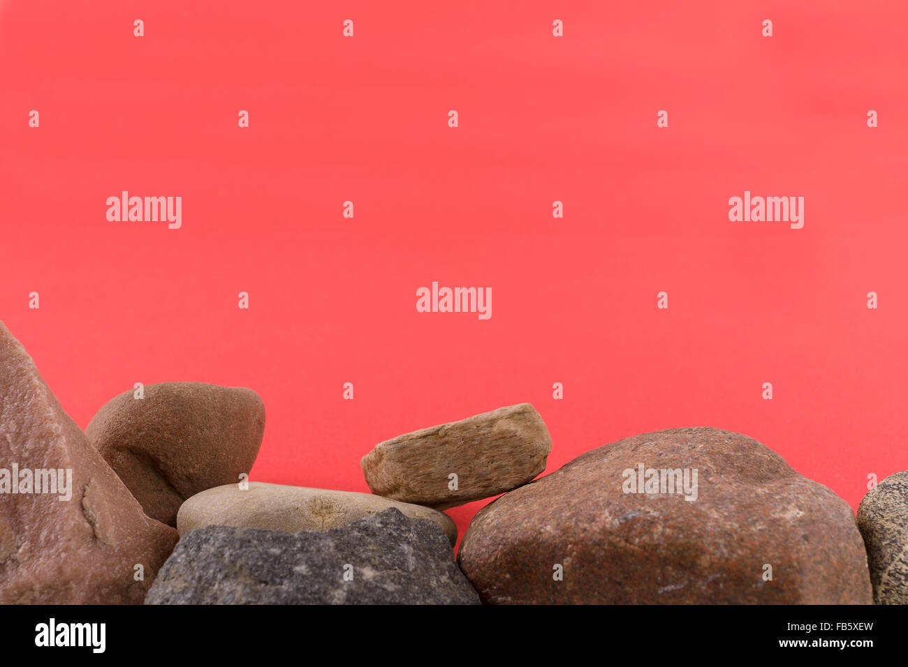long line of stones on a red background Stock Photo - Alamy