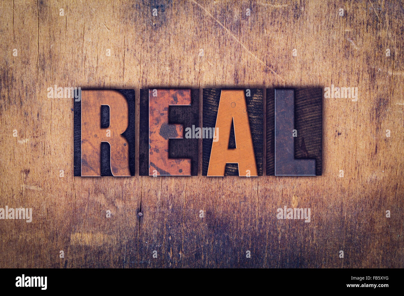 The word "Real" written in dirty vintage letterpress type on a aged ...