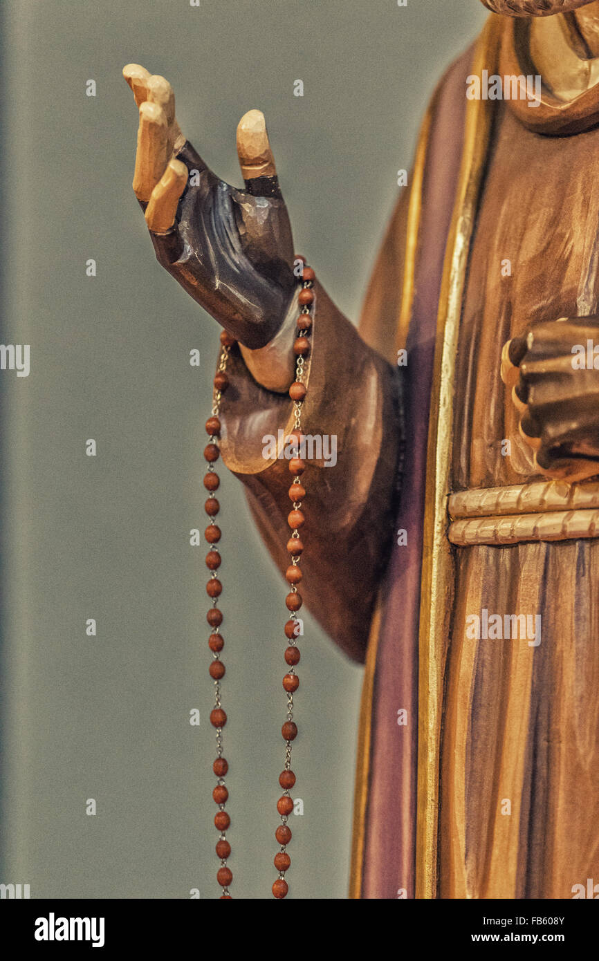 detail of a wood carved statue of Saint Father Pius with his gloved ...