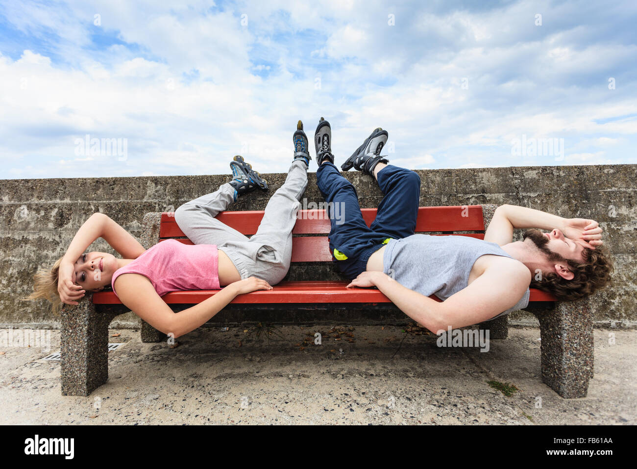 Young tired people friends in training suit with roller skates. Woman ...