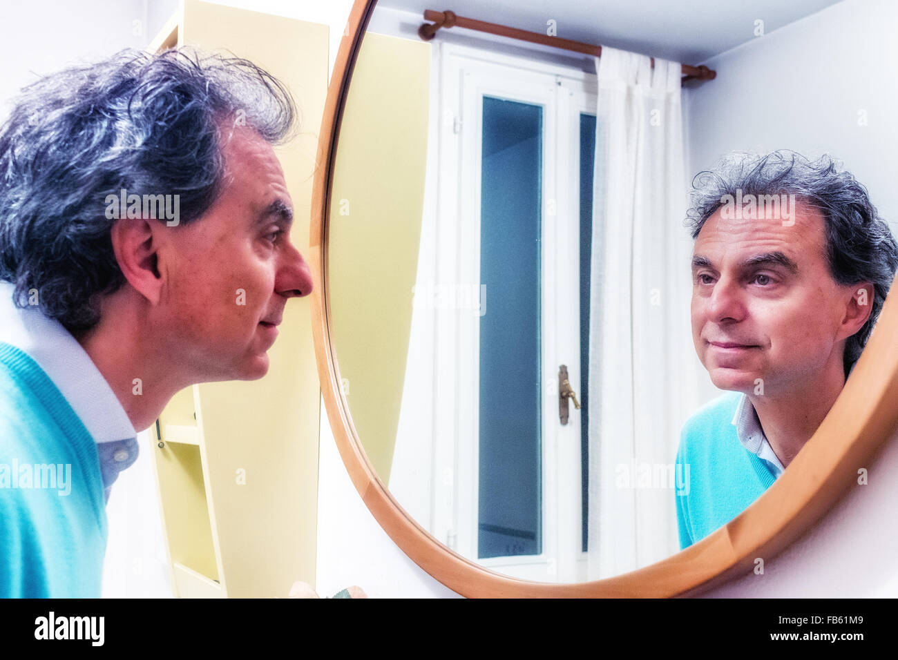 handsome middle-aged man looking in the mirror with nice look Stock ...