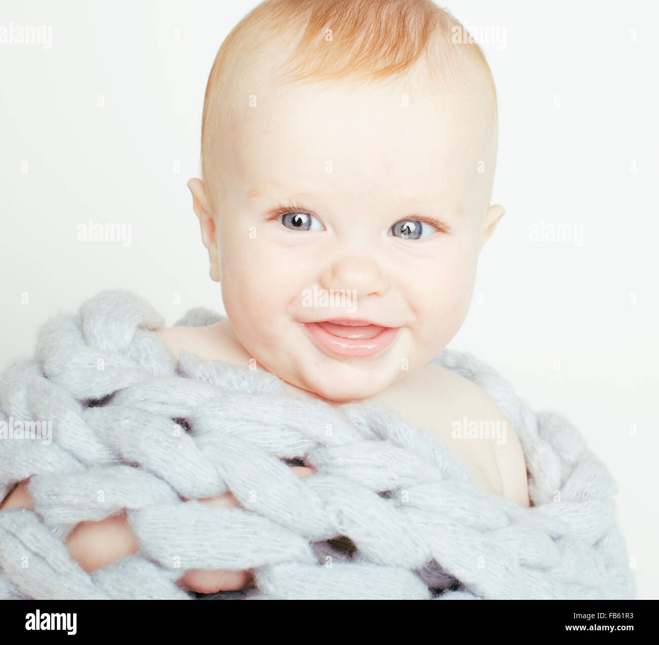 little cute red head baby in scarf all over him close up isolated ...