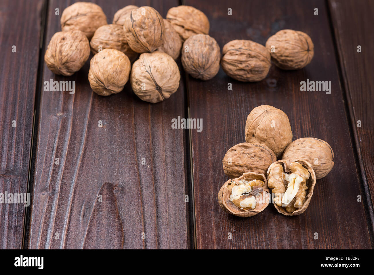 Walnut kernels and whole walnuts on rustic old wooden table Stock Photo ...
