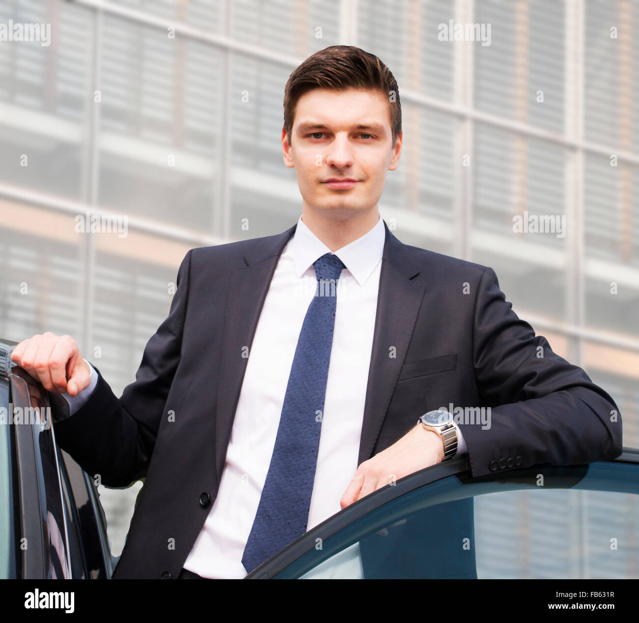 Young businessman standing near his car Stock Photo - Alamy