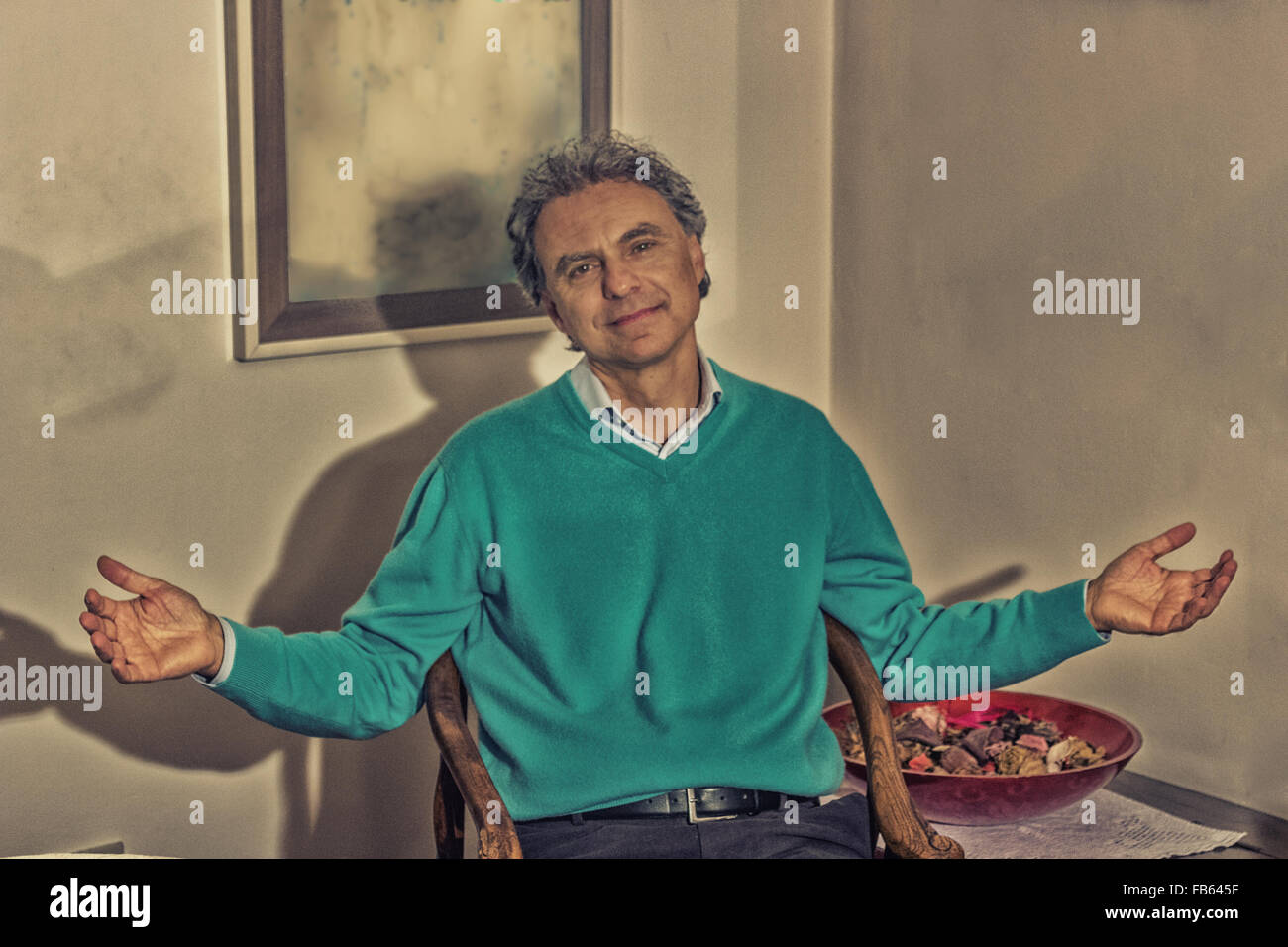 middle-aged man opens arms waving while sitting Stock Photo - Alamy